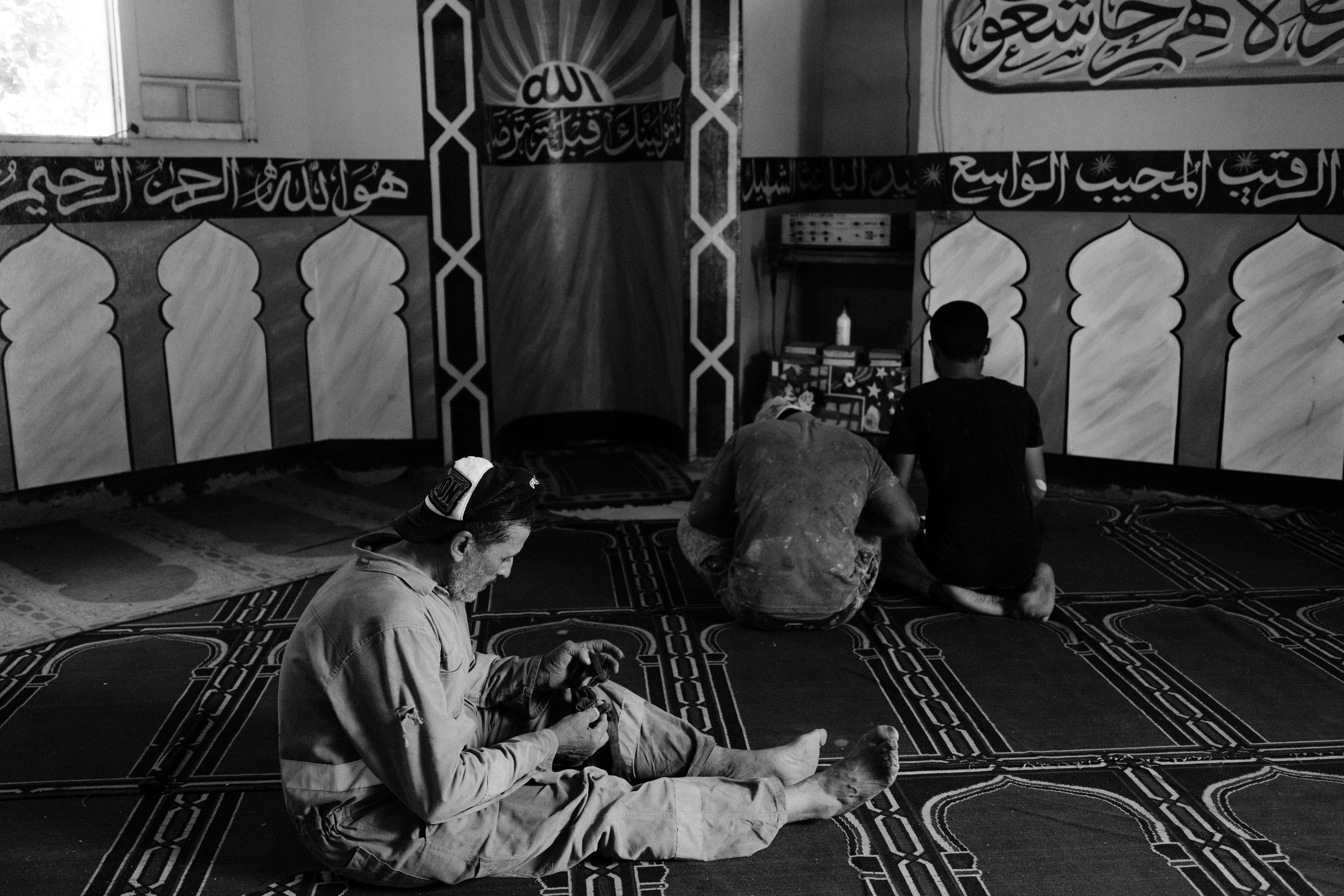 Black and White Mosque Interior with Worshippers · Free Stock Photo