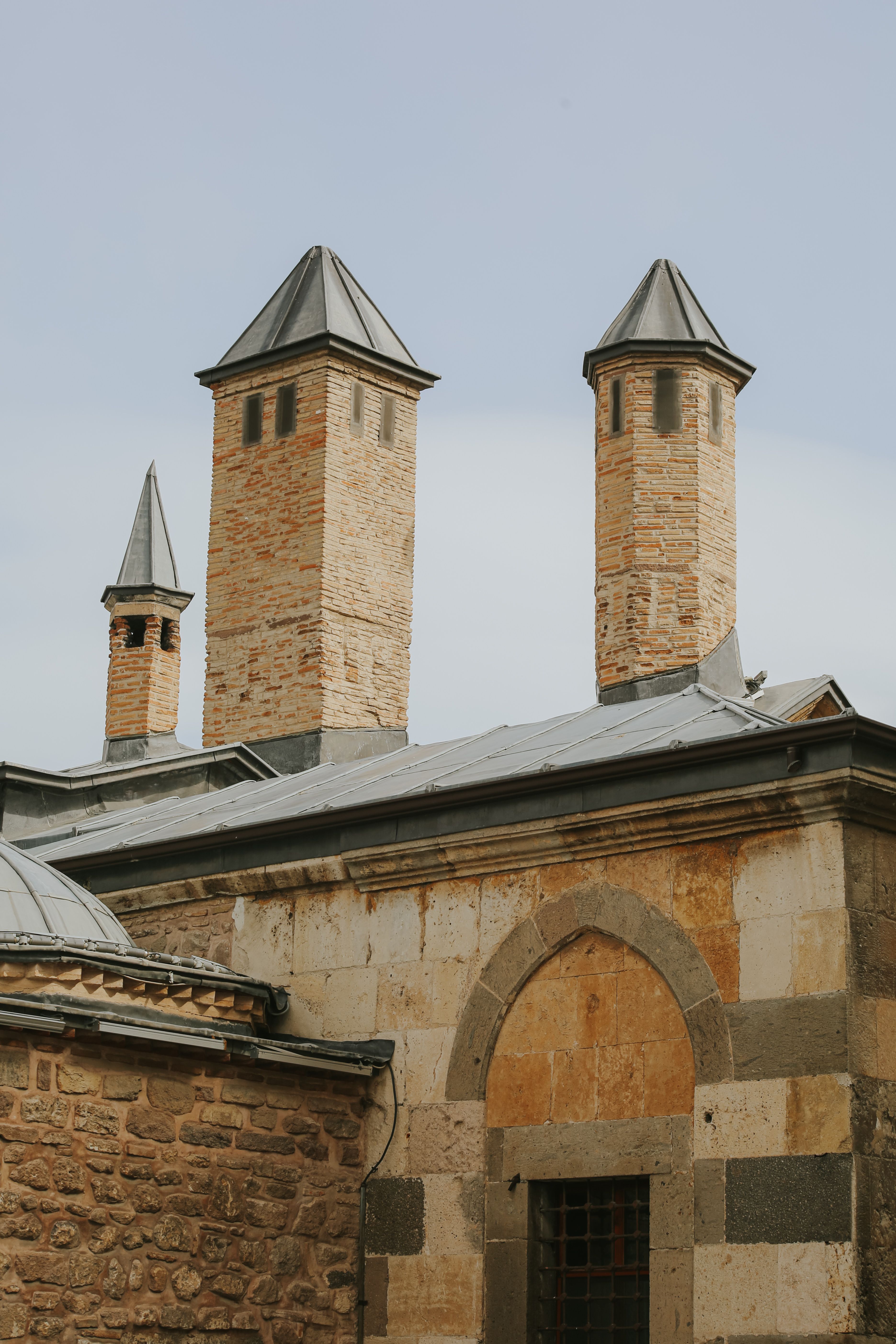 Historic Stone Building with Tall Chimneys · Free Stock Photo