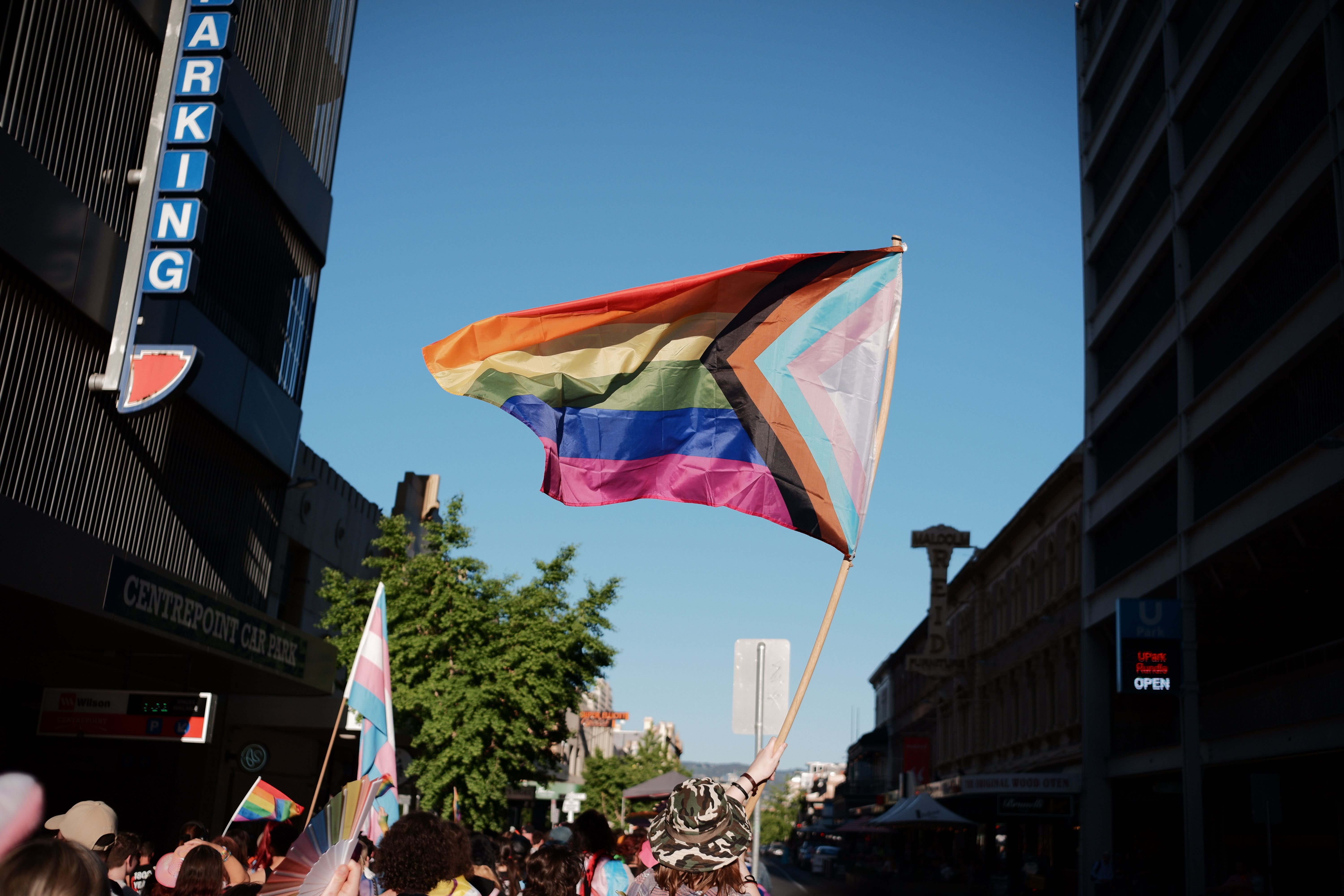 Colorful Pride Flag in Urban Parade Setting · Free Stock Photo