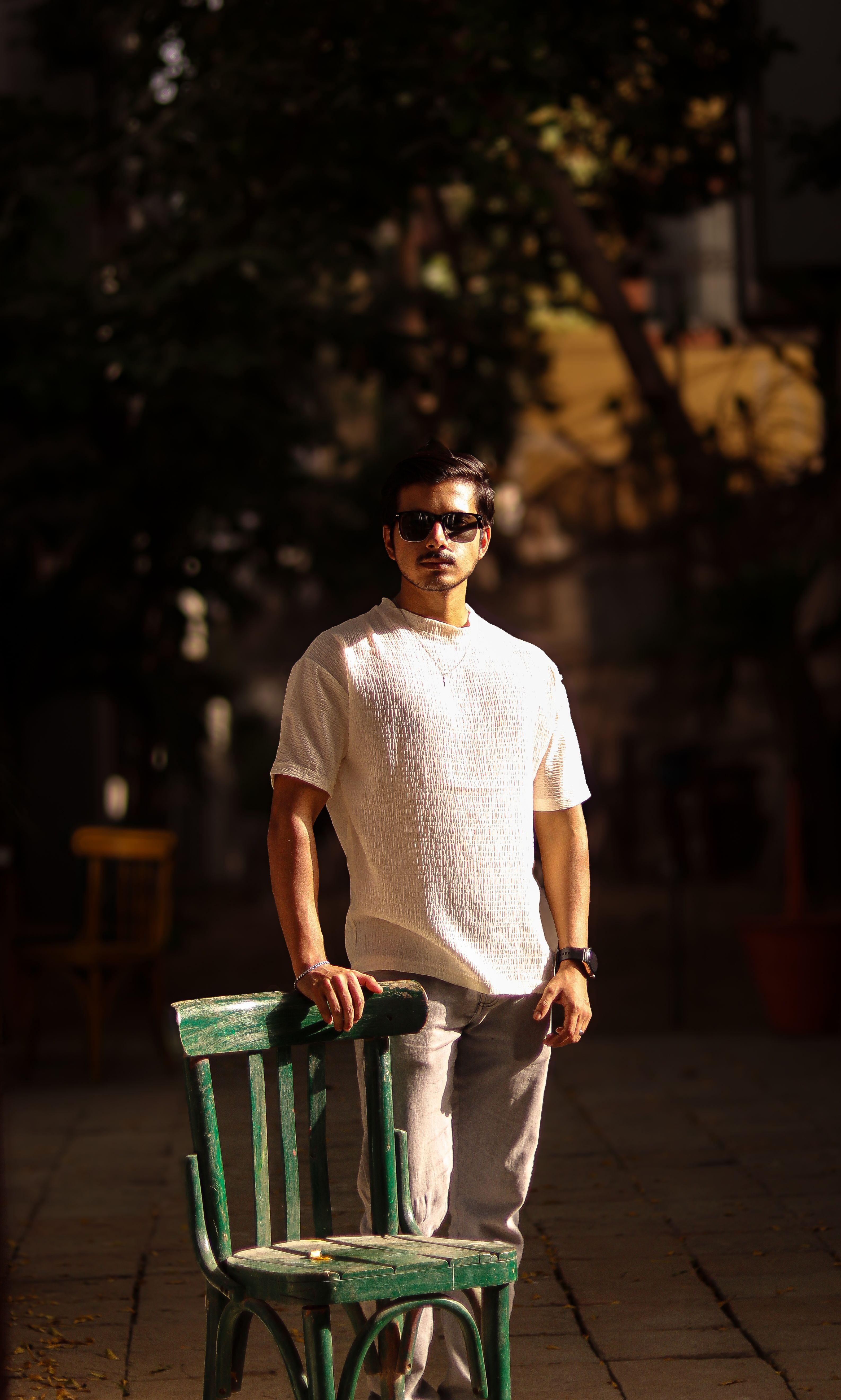 Stylish Man Posing Outdoors with Chair · Free Stock Photo