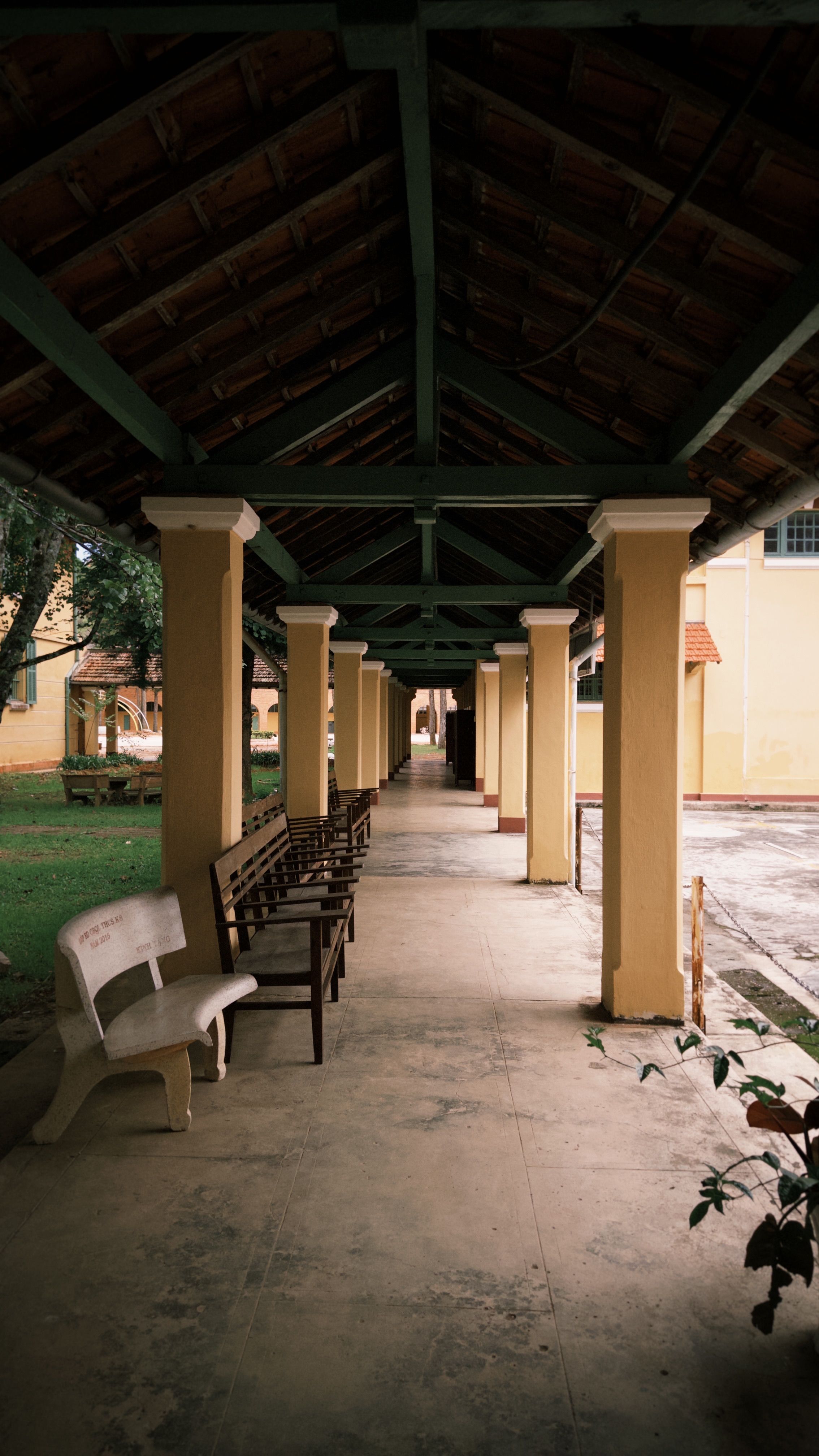 Rustic Covered Walkway with Benches and Columns · Free Stock Photo