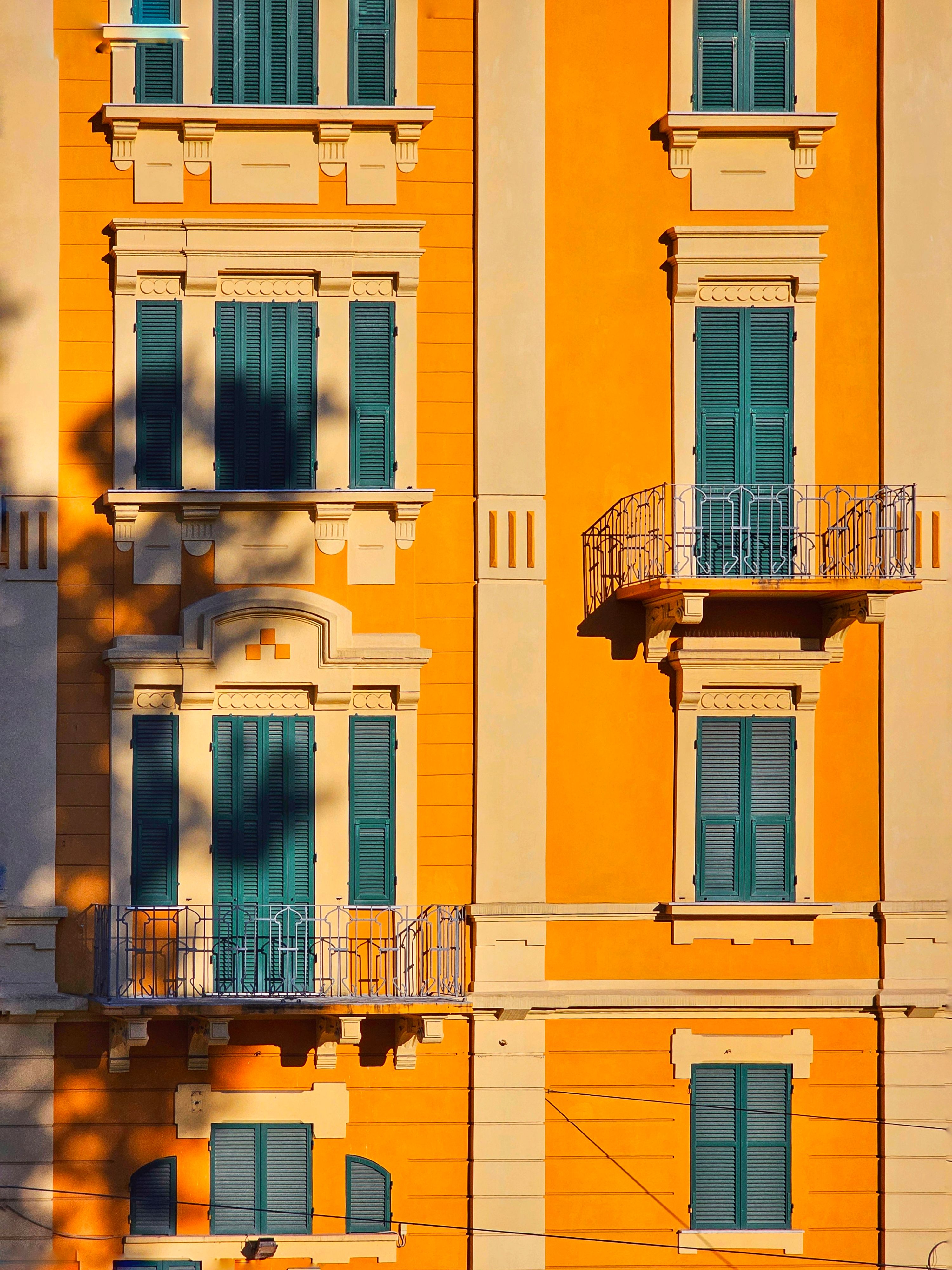 Vibrant Orange Building with Classic Shutters · Free Stock Photo