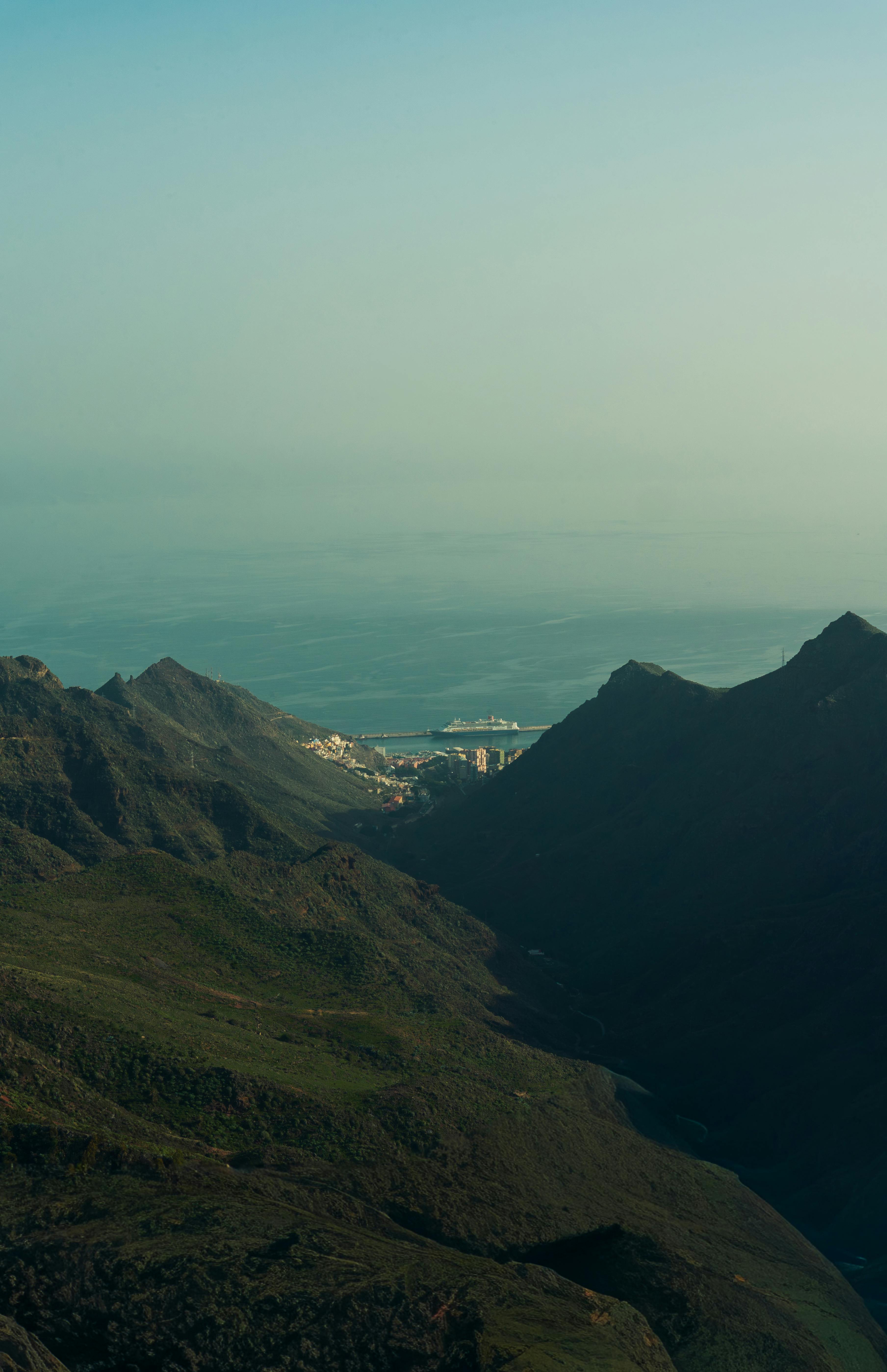 Stunning Mountain Valley Overlooking Coastal Town · Free Stock Photo
