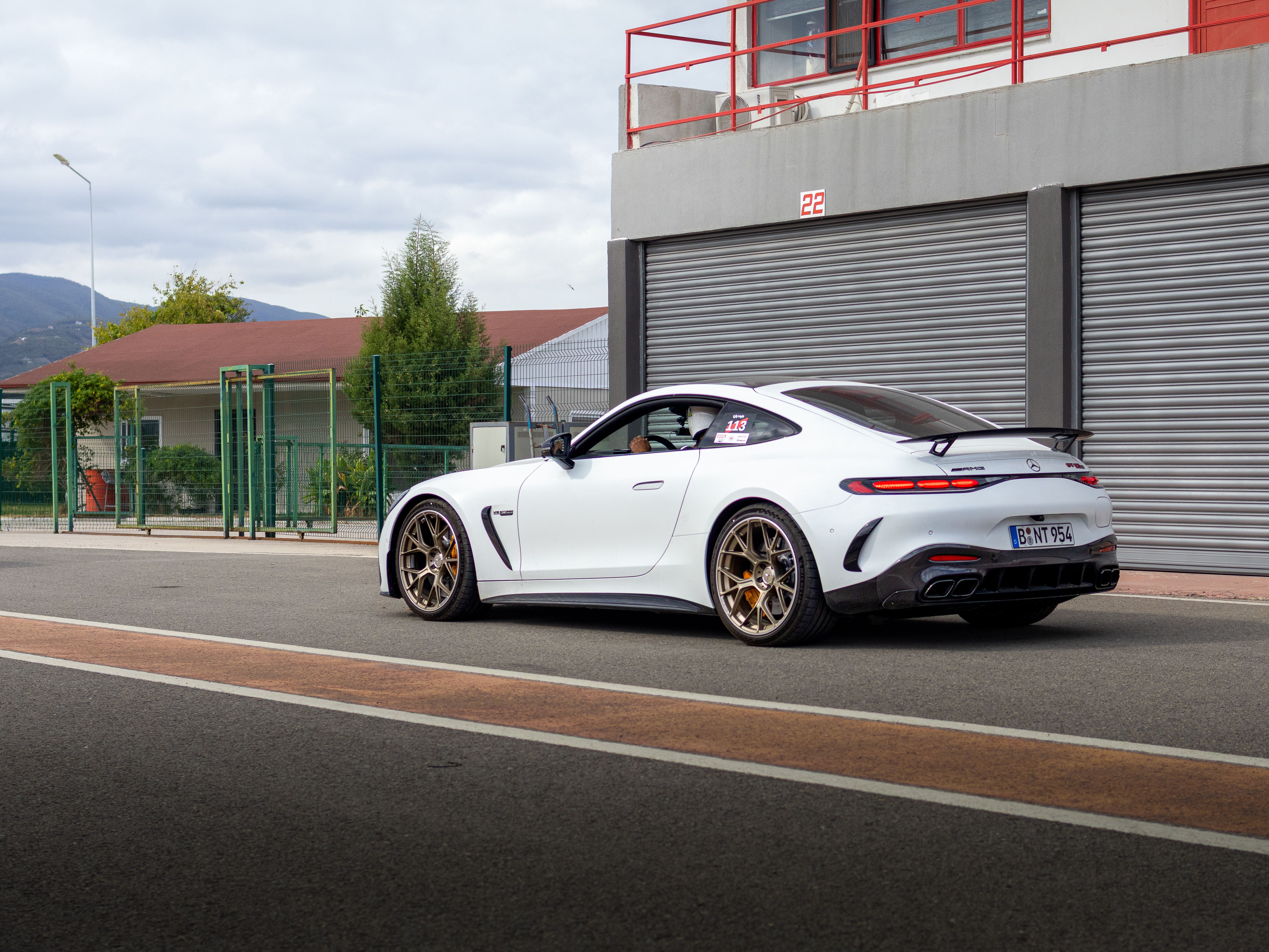 Sleek White Sports Car on Race Track Pitstop · Free Stock Photo