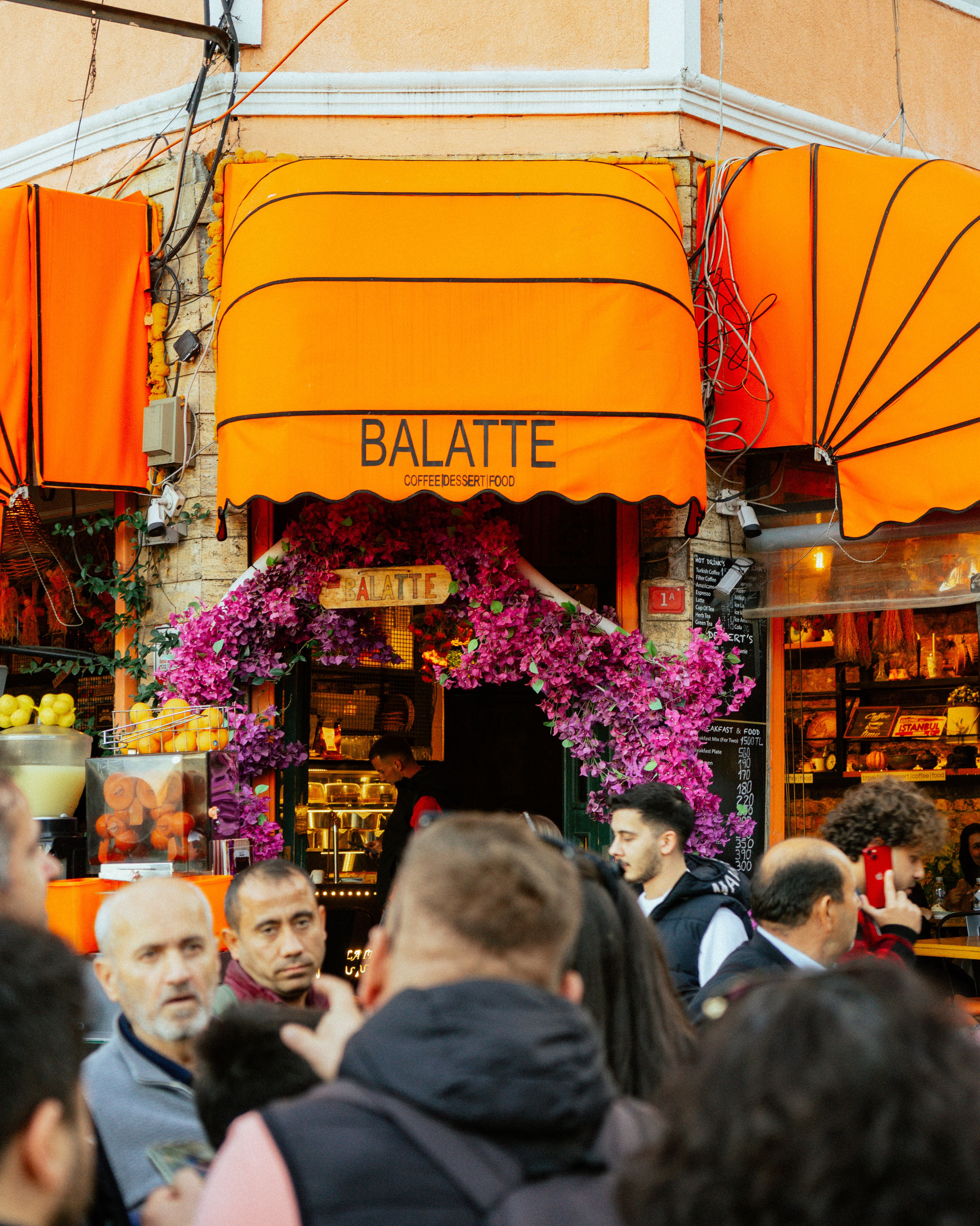 Lively Street Scene at Balatte Café Entrance · Free Stock Photo