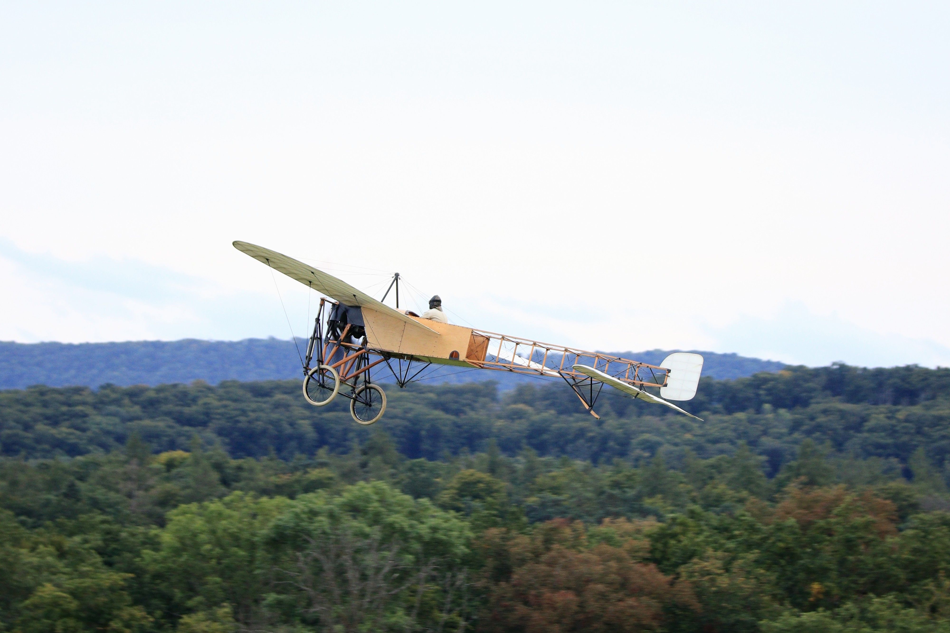 Vintage Aircraft Flying Over Forest Landscape · Free Stock Photo