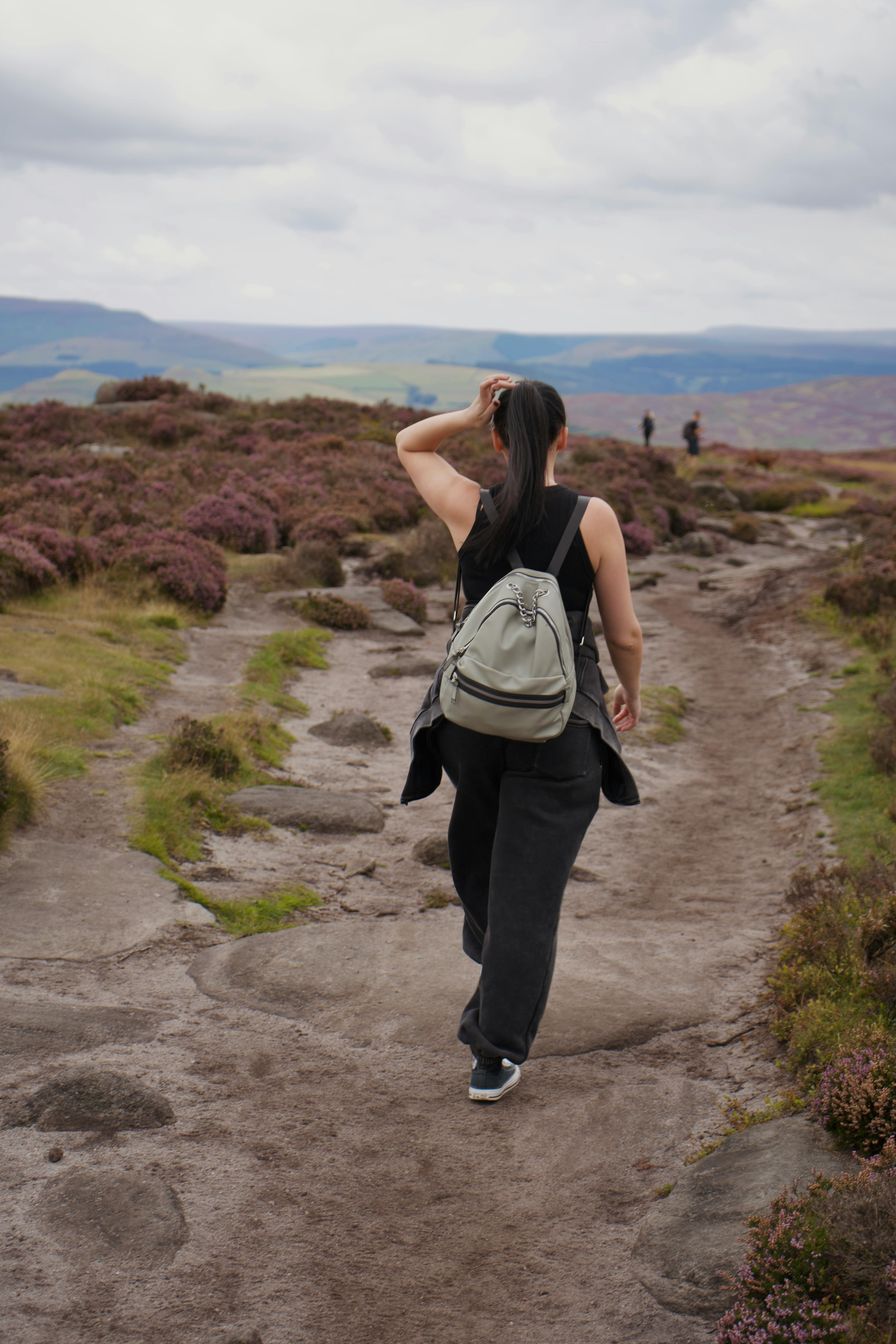 Woman Hiking on Rocky Path in Scenic Countryside · Free Stock Photo