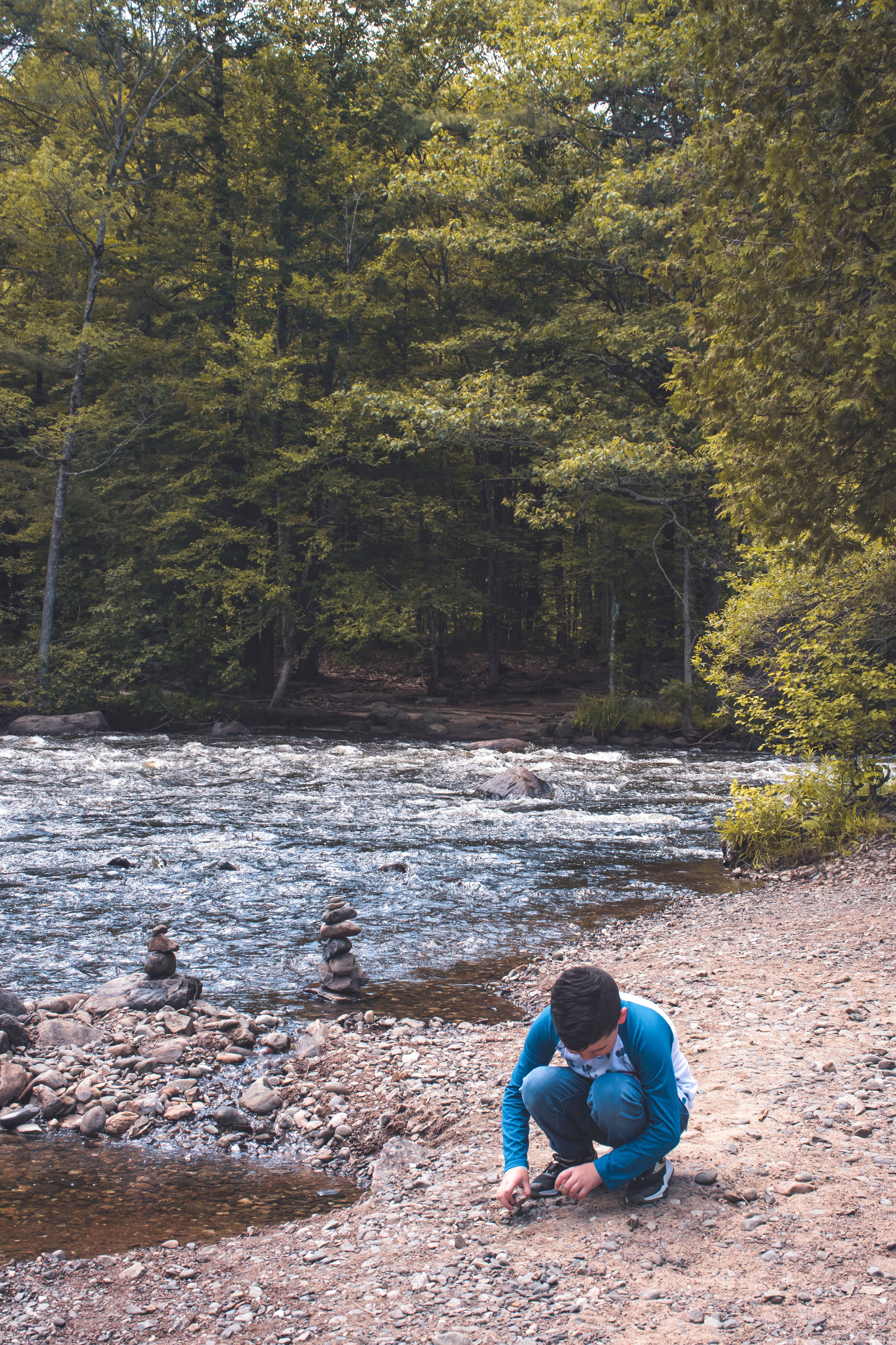 Child Exploring Nature by a Riverbank · Free Stock Photo