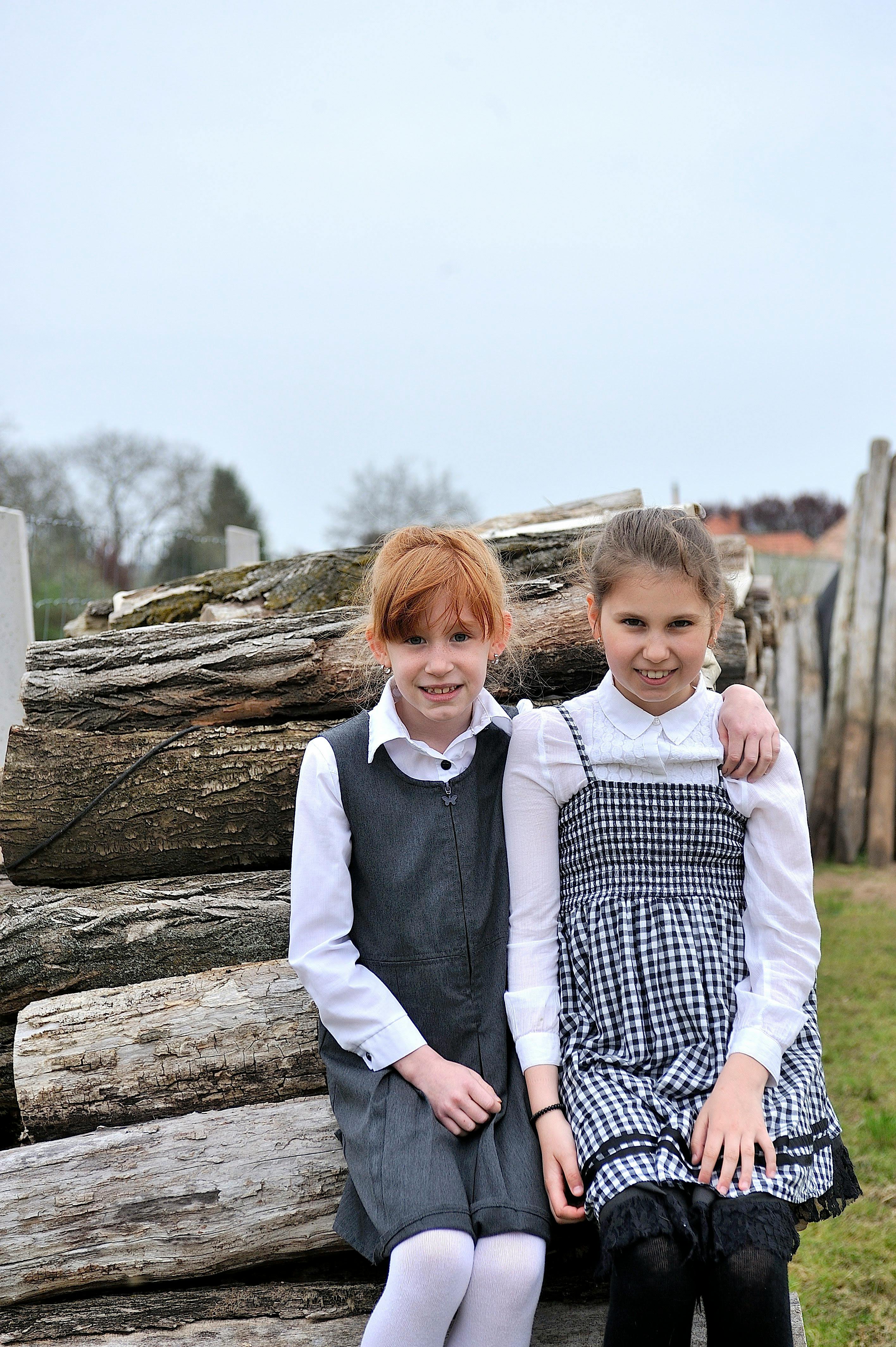 Two Girls Posing Outdoors in School Uniforms · Free Stock Photo