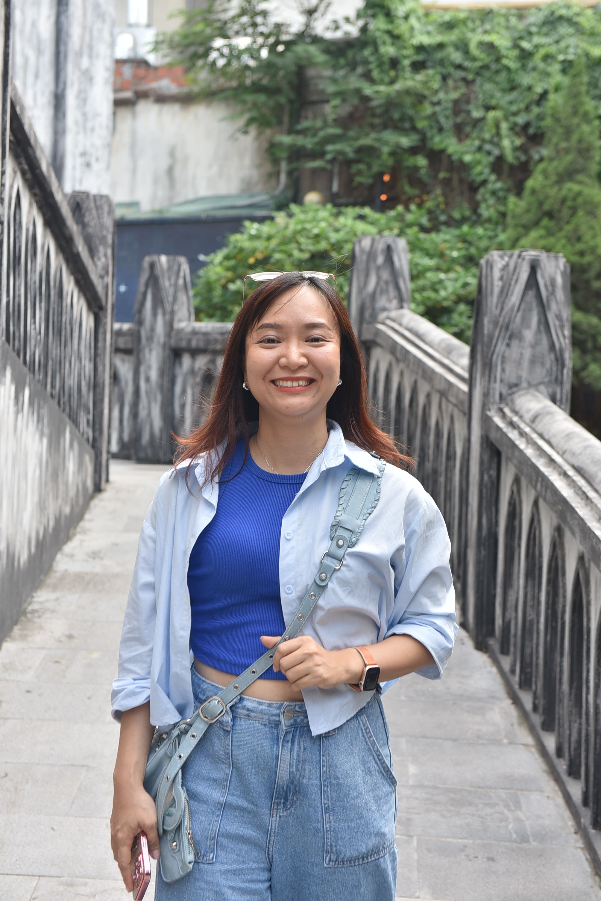 Smiling Woman Walking on Stone Bridge Outdoors · Free Stock Photo