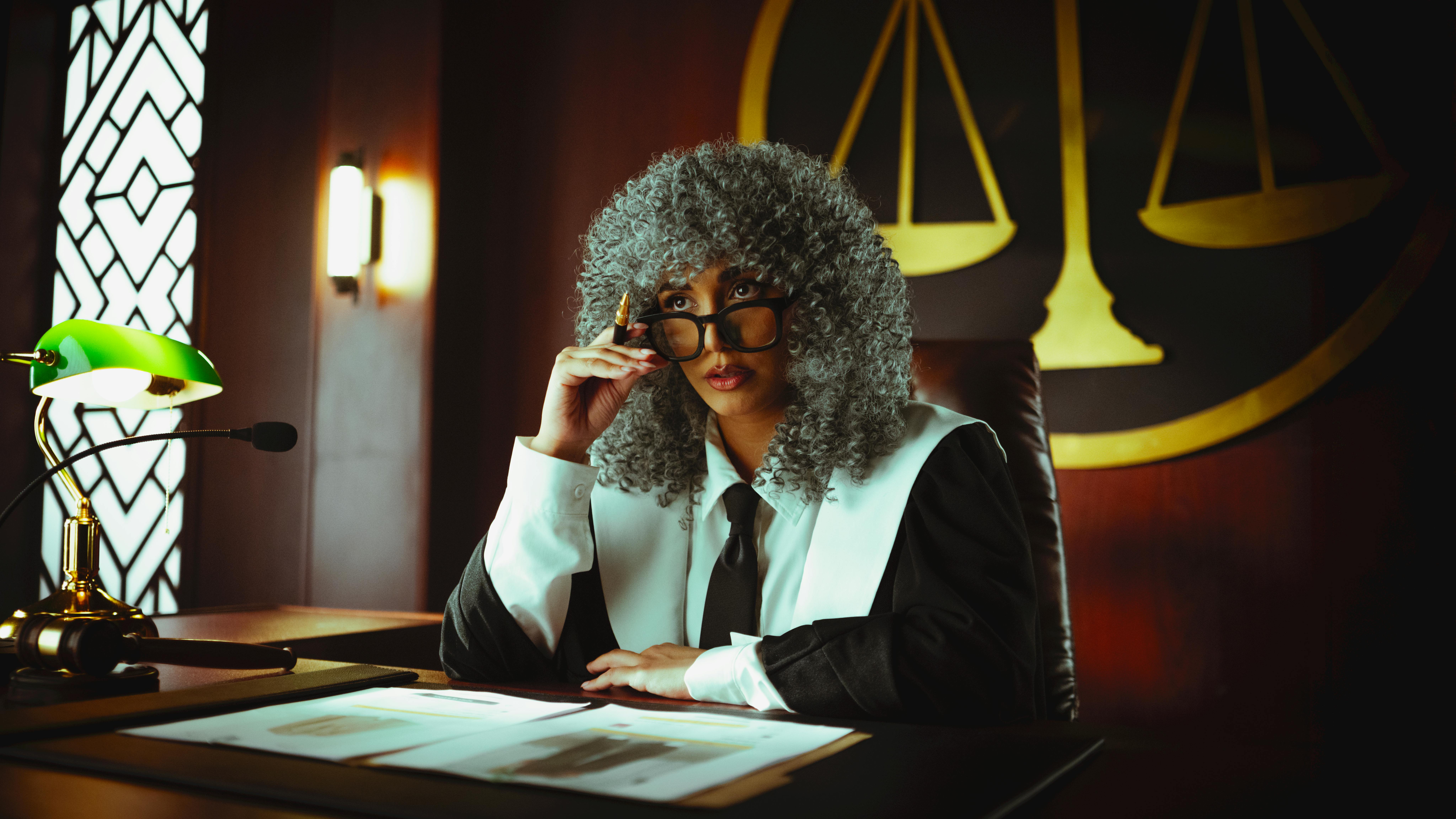 Judge in Traditional Attire at Courtroom Desk · Free Stock Photo