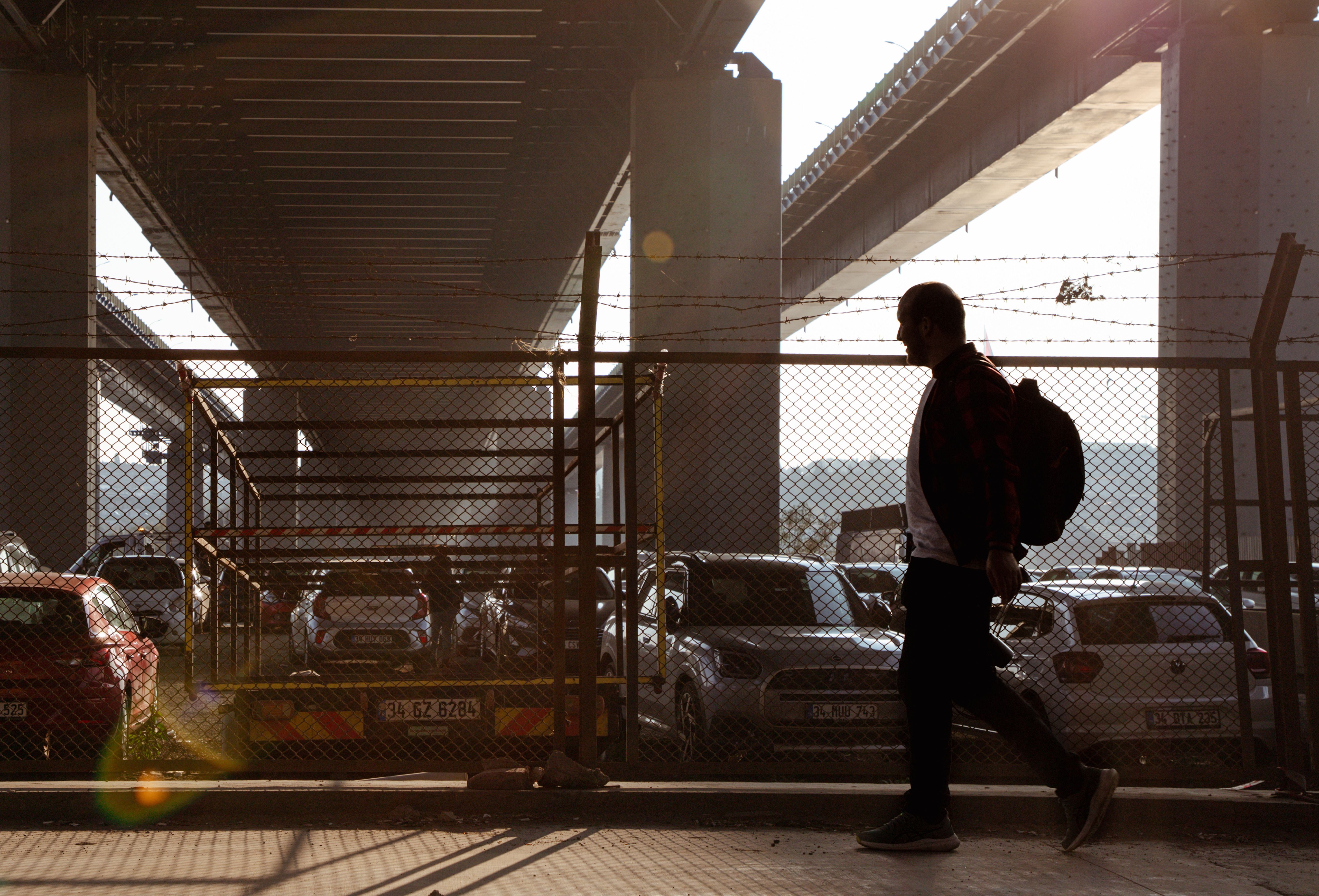 Silhouette of Man Walking Under Urban Overpass · Free Stock Photo