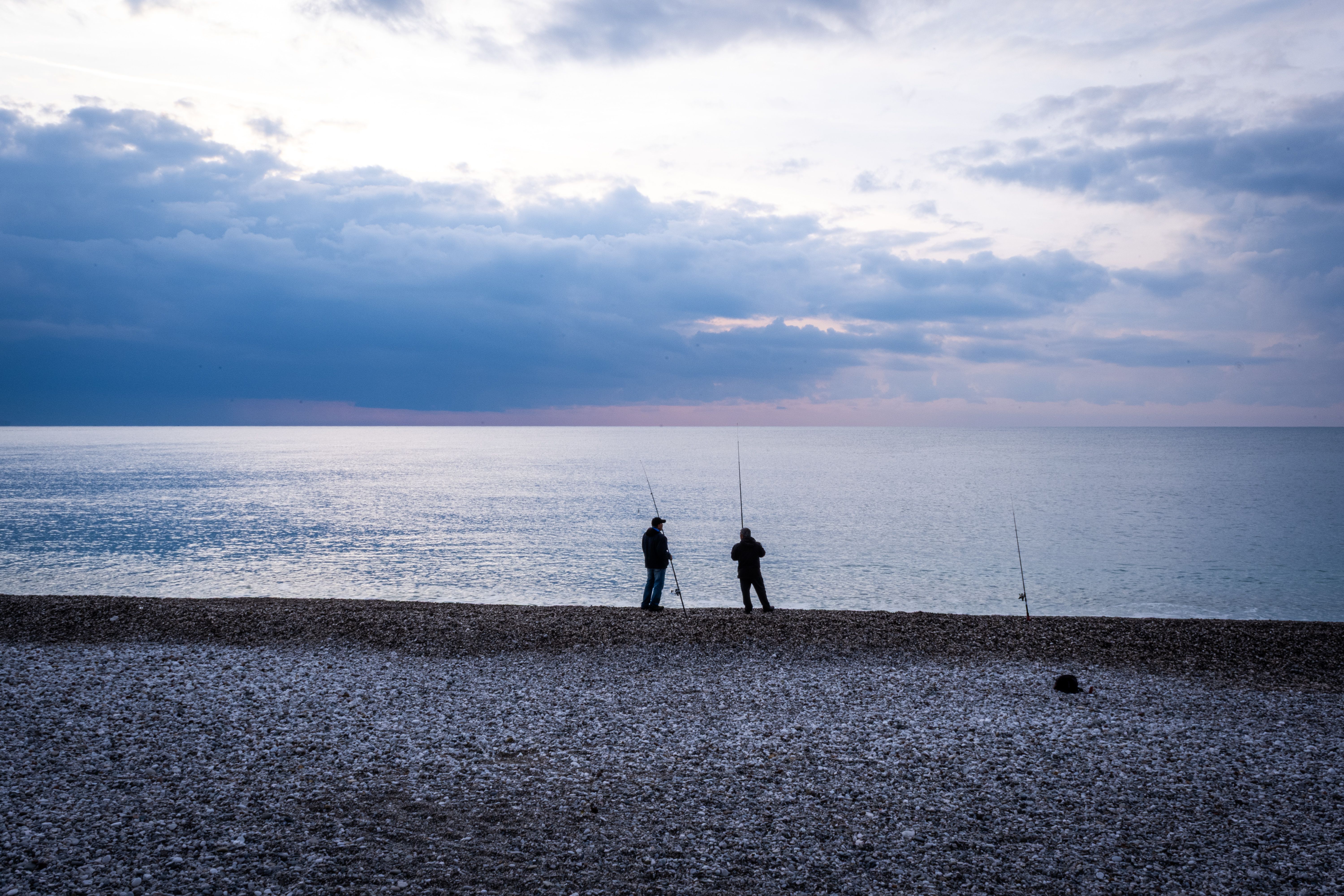 Serene Beach Fishing at Twilight · Free Stock Photo