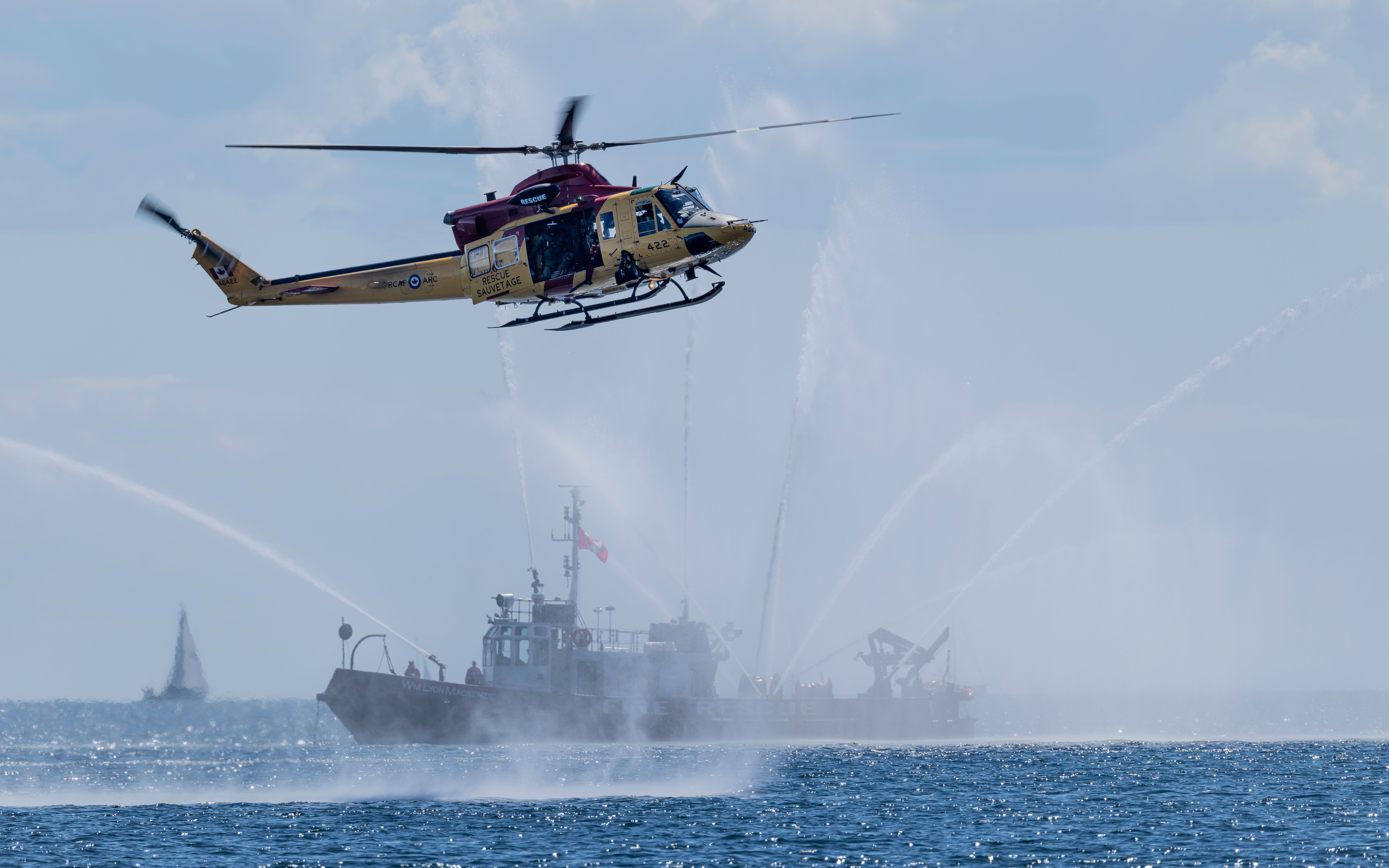 Rescue Helicopter Hovering Over Sea with Boat · Free Stock Photo