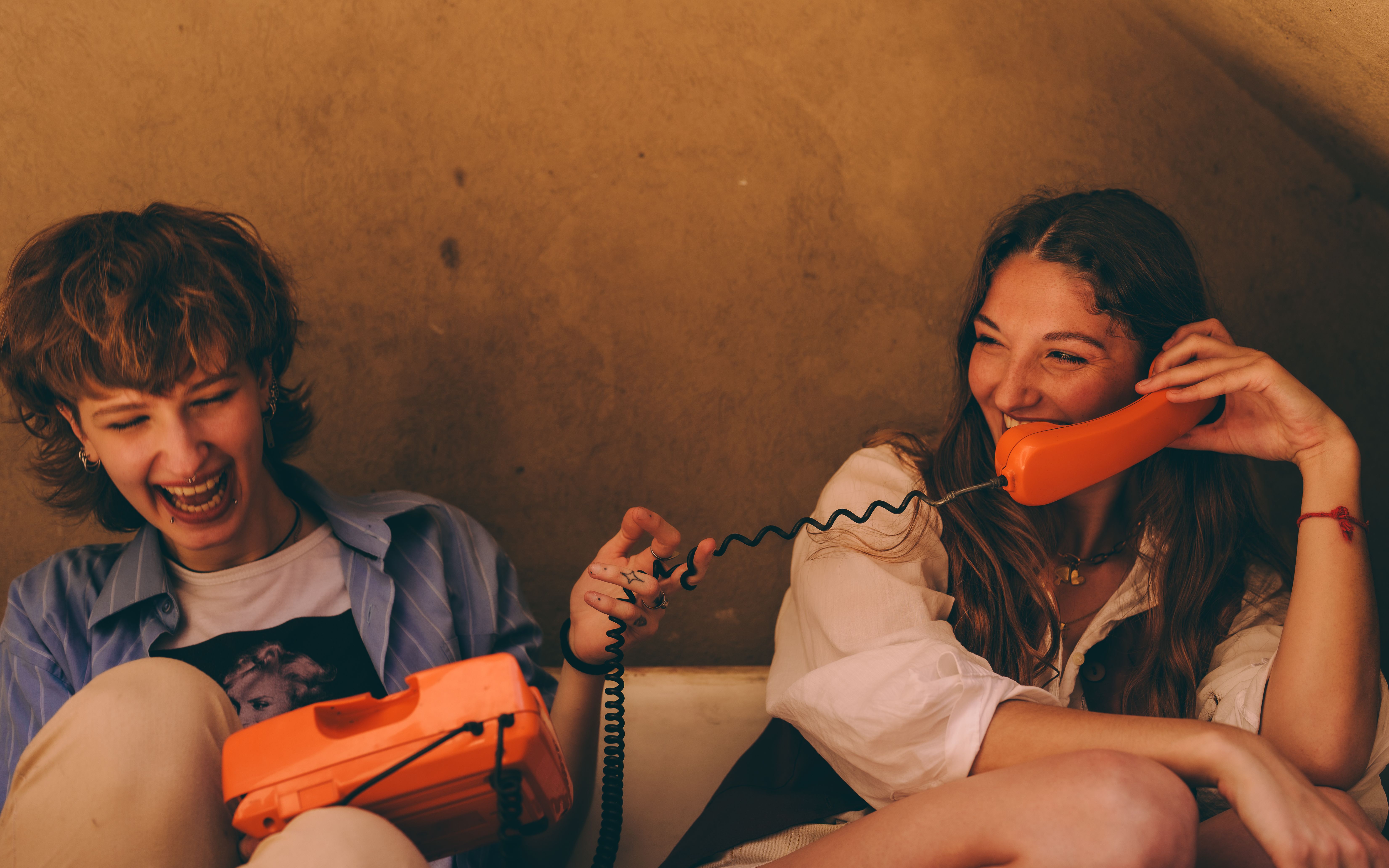 Friends Sharing Laughter While Using Retro Telephone · Free Stock Photo