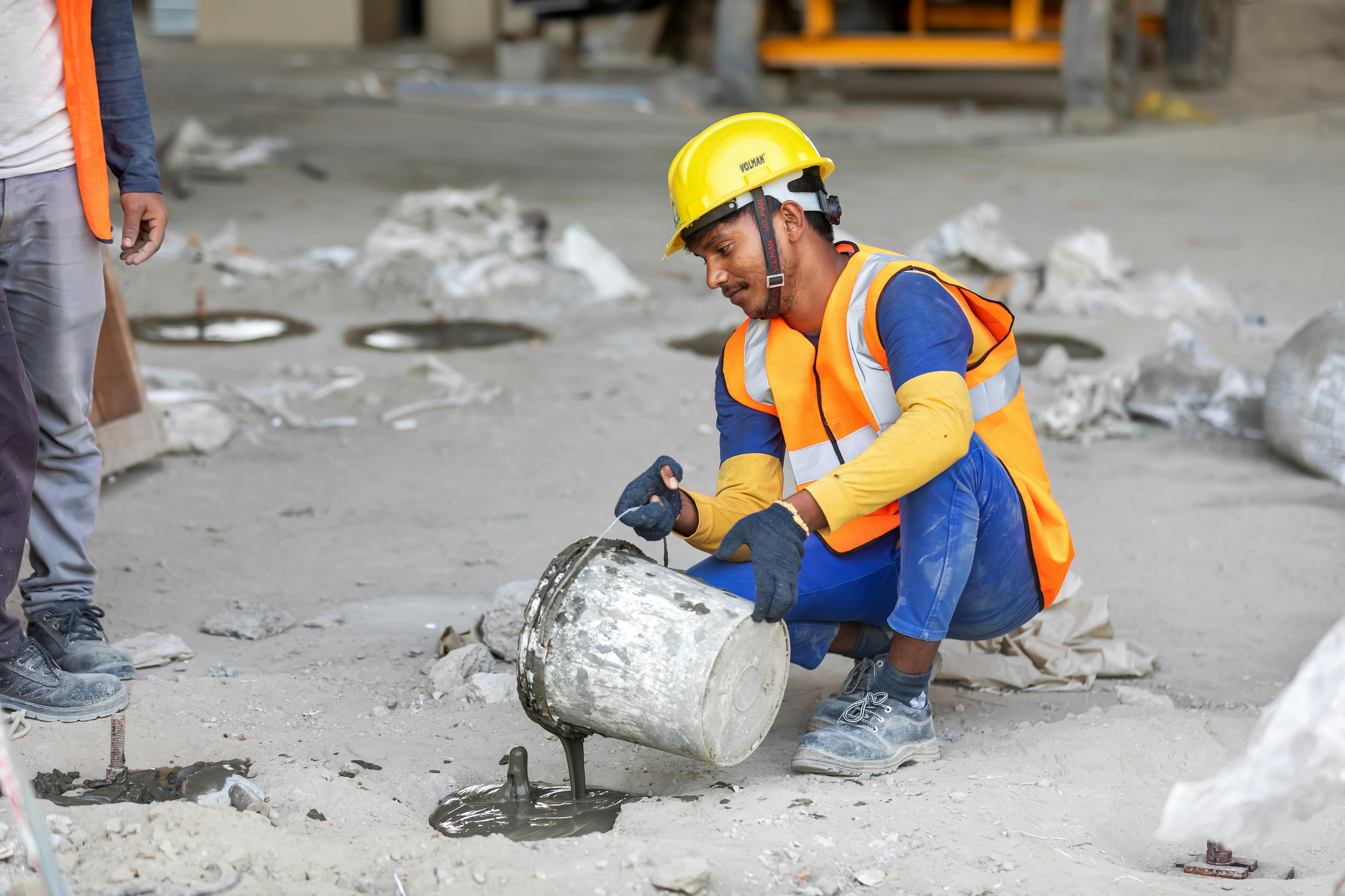 Construction Worker Pouring Concrete on Site · Free Stock Photo