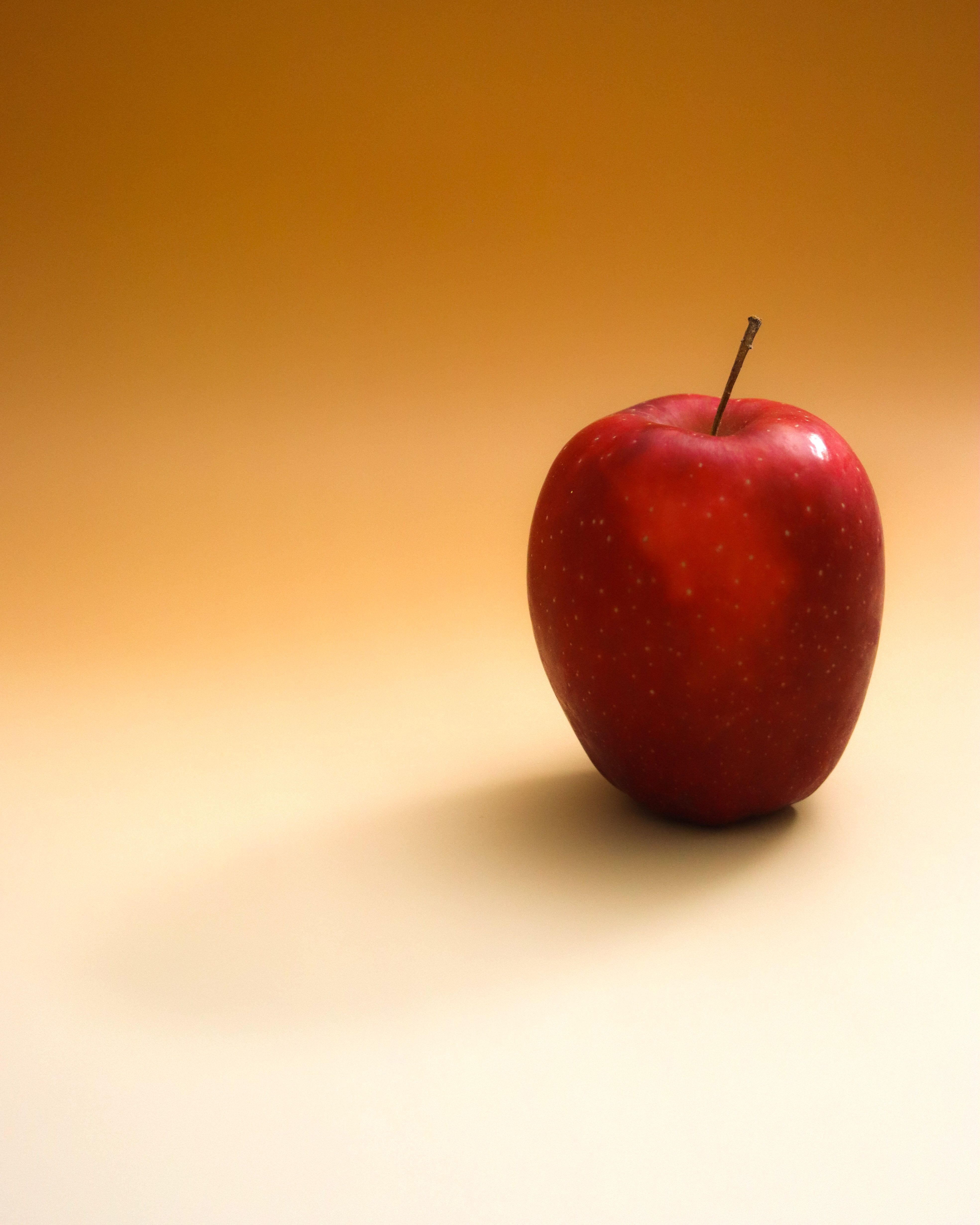 Shallow Focus Photography of Red Apple on Gray Pavement · Free Stock Photo