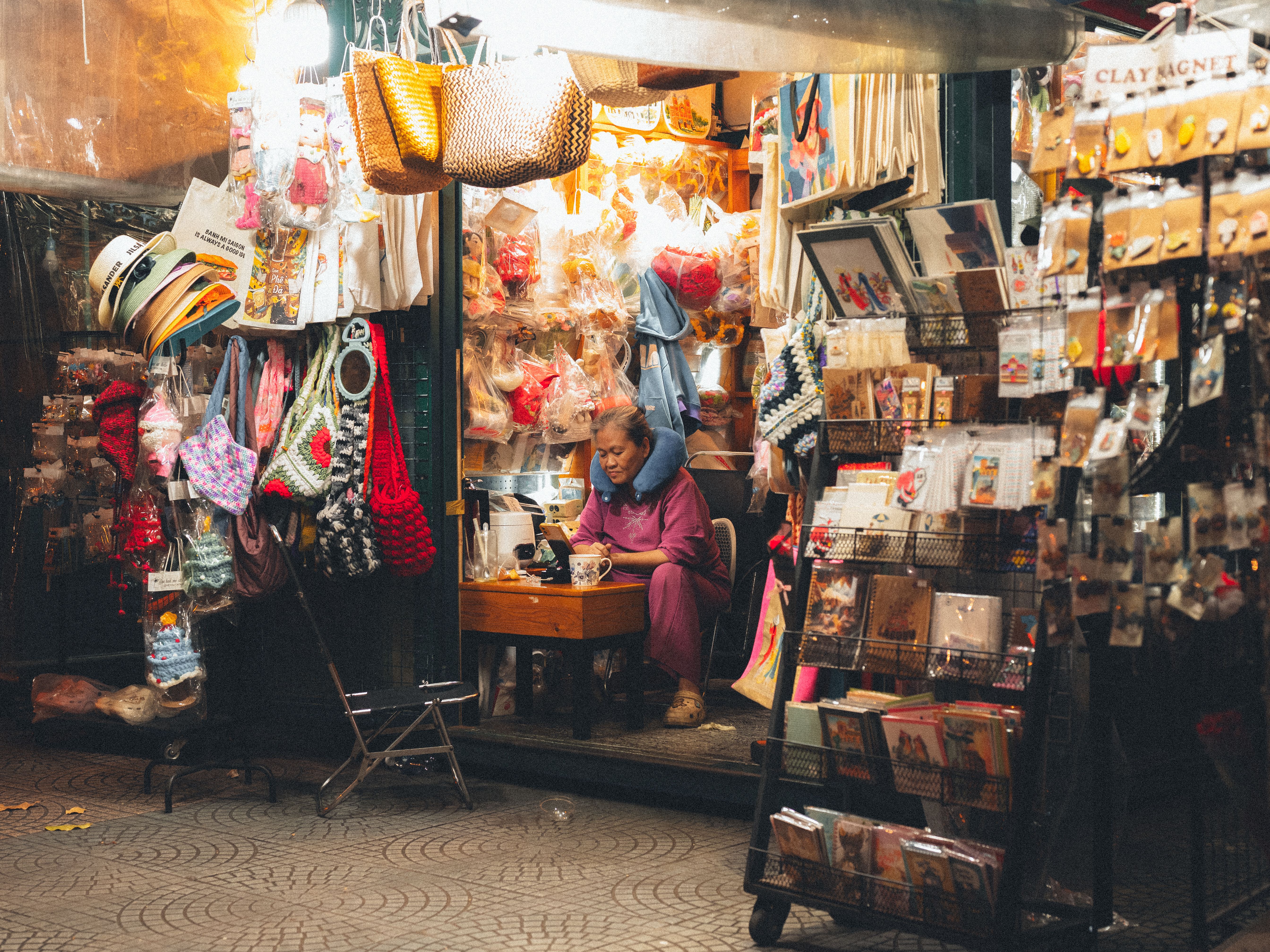 Street Vendor at Night Market Booth Selling Crafts · Free Stock Photo