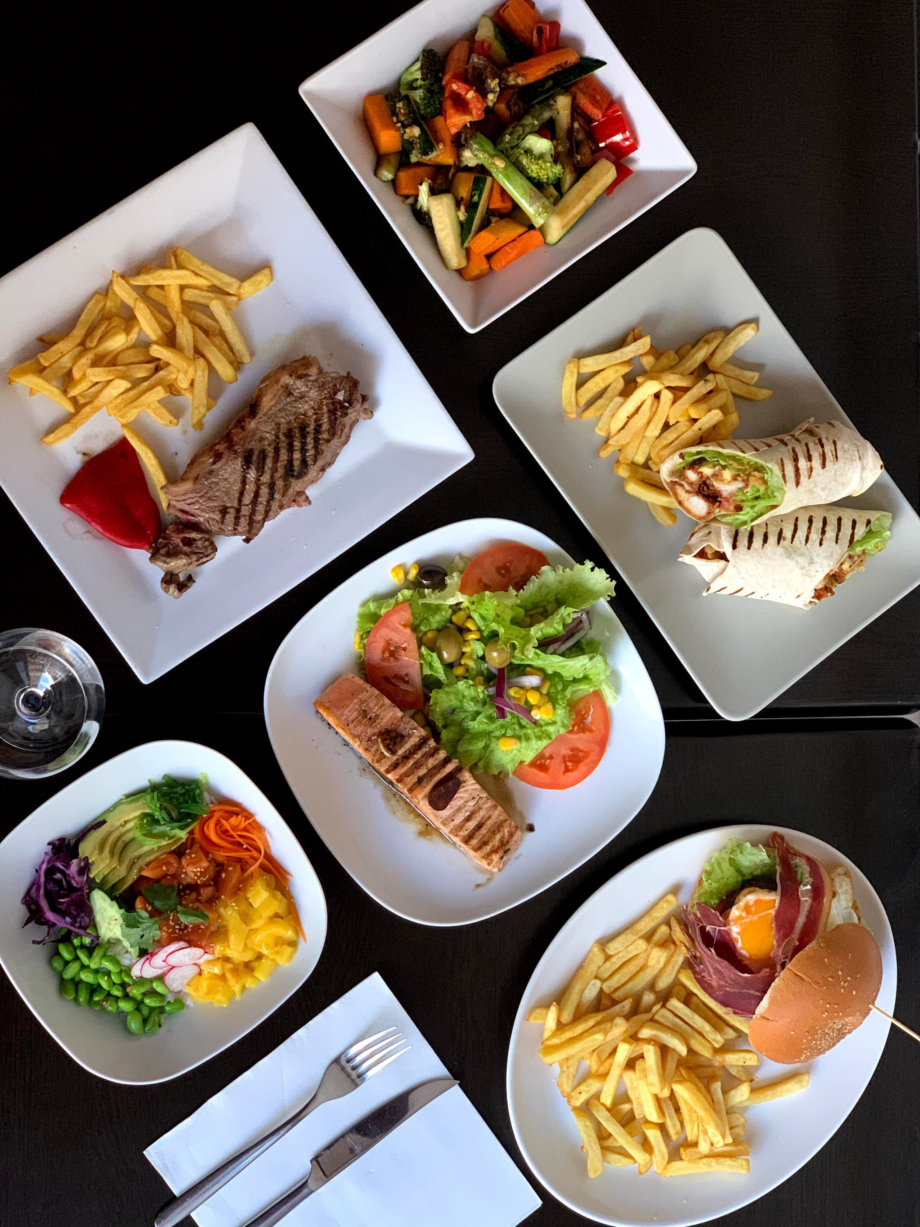 Variety of Appetizing Meals on White Plates · Free Stock Photo