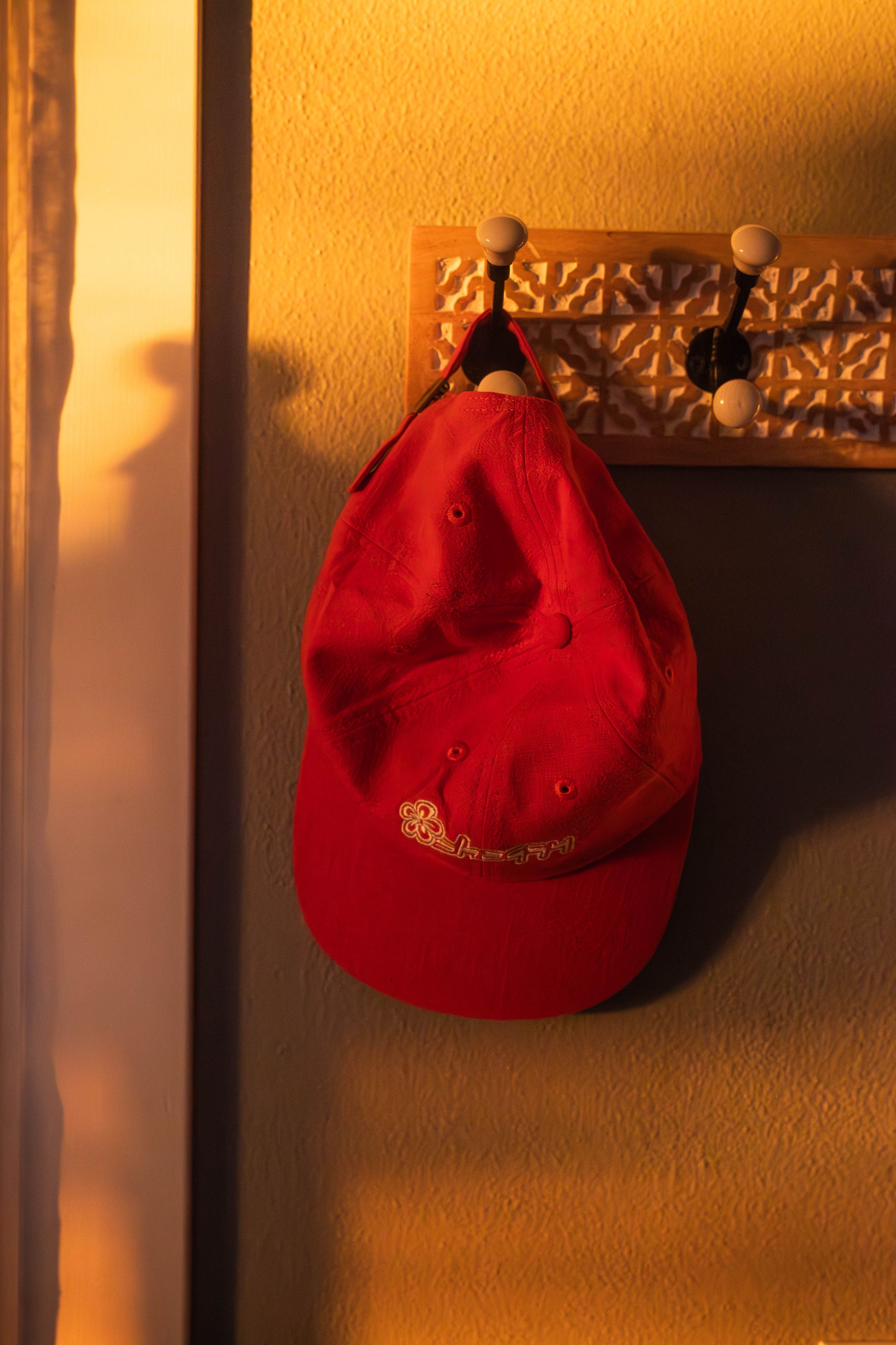 Red Cap Hanging in Warm Sunset Light · Free Stock Photo