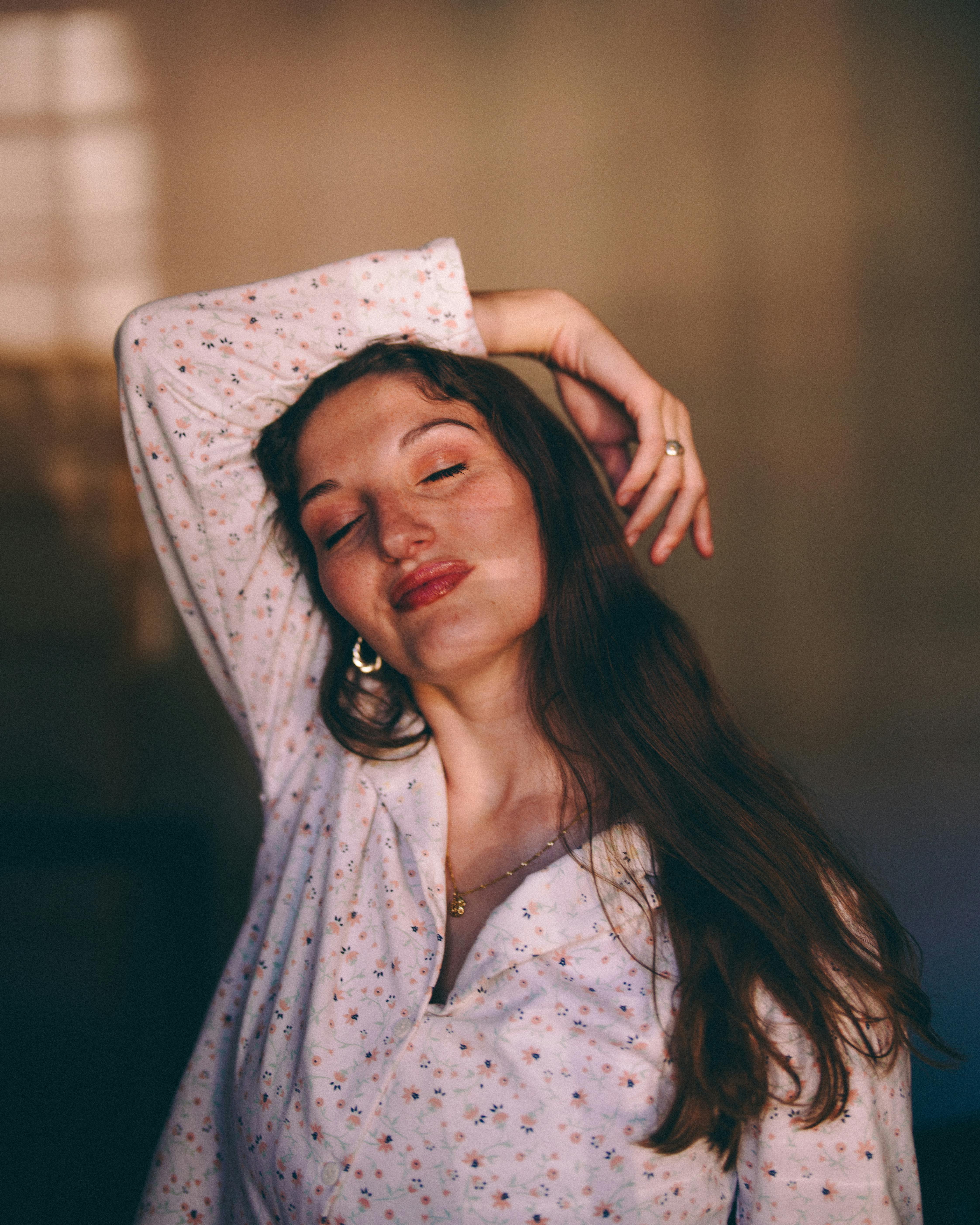 Relaxed Woman Posing in Warm Light Indoors · Free Stock Photo