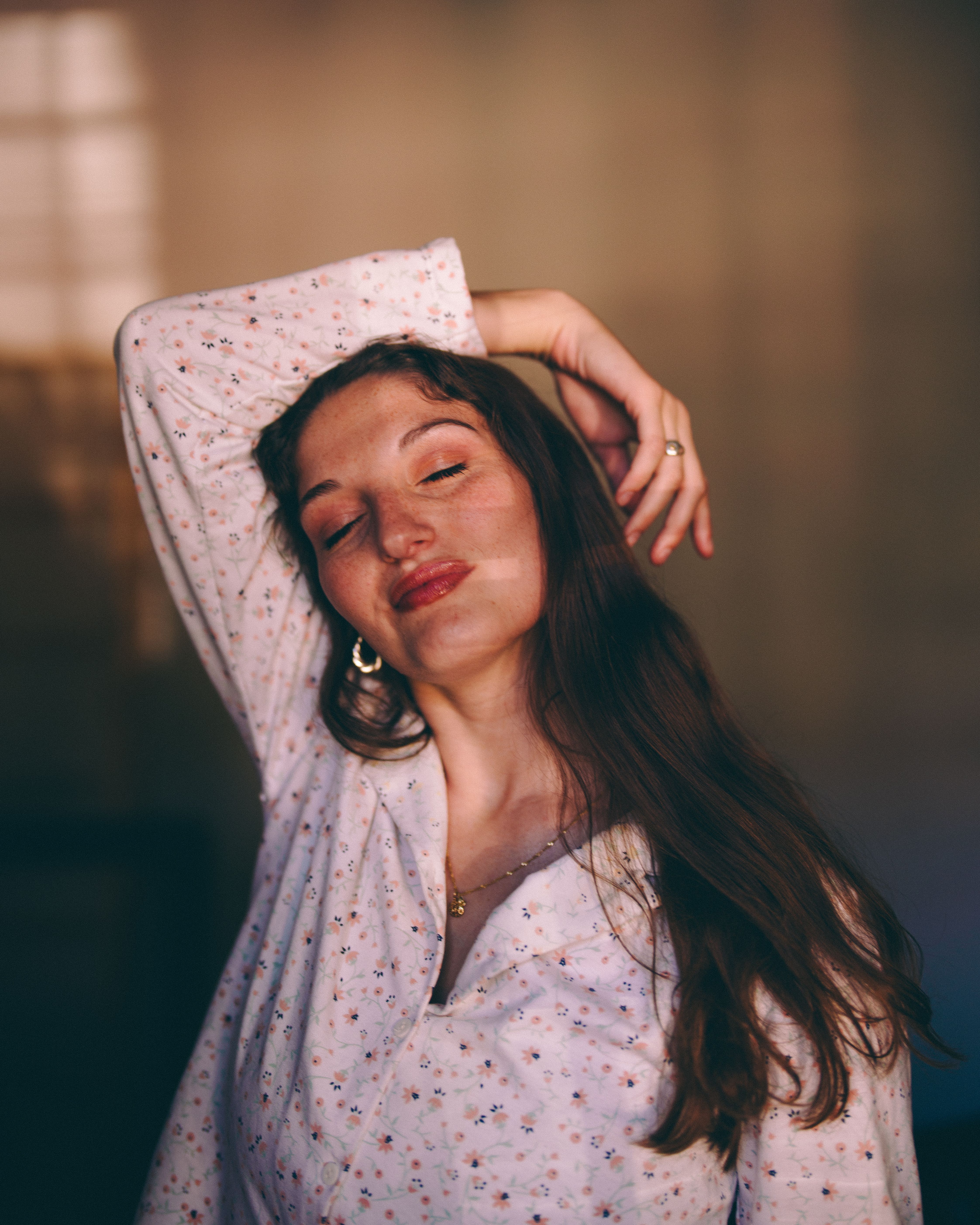 Relaxed Woman Posing in Warm Light Indoors · Free Stock Photo