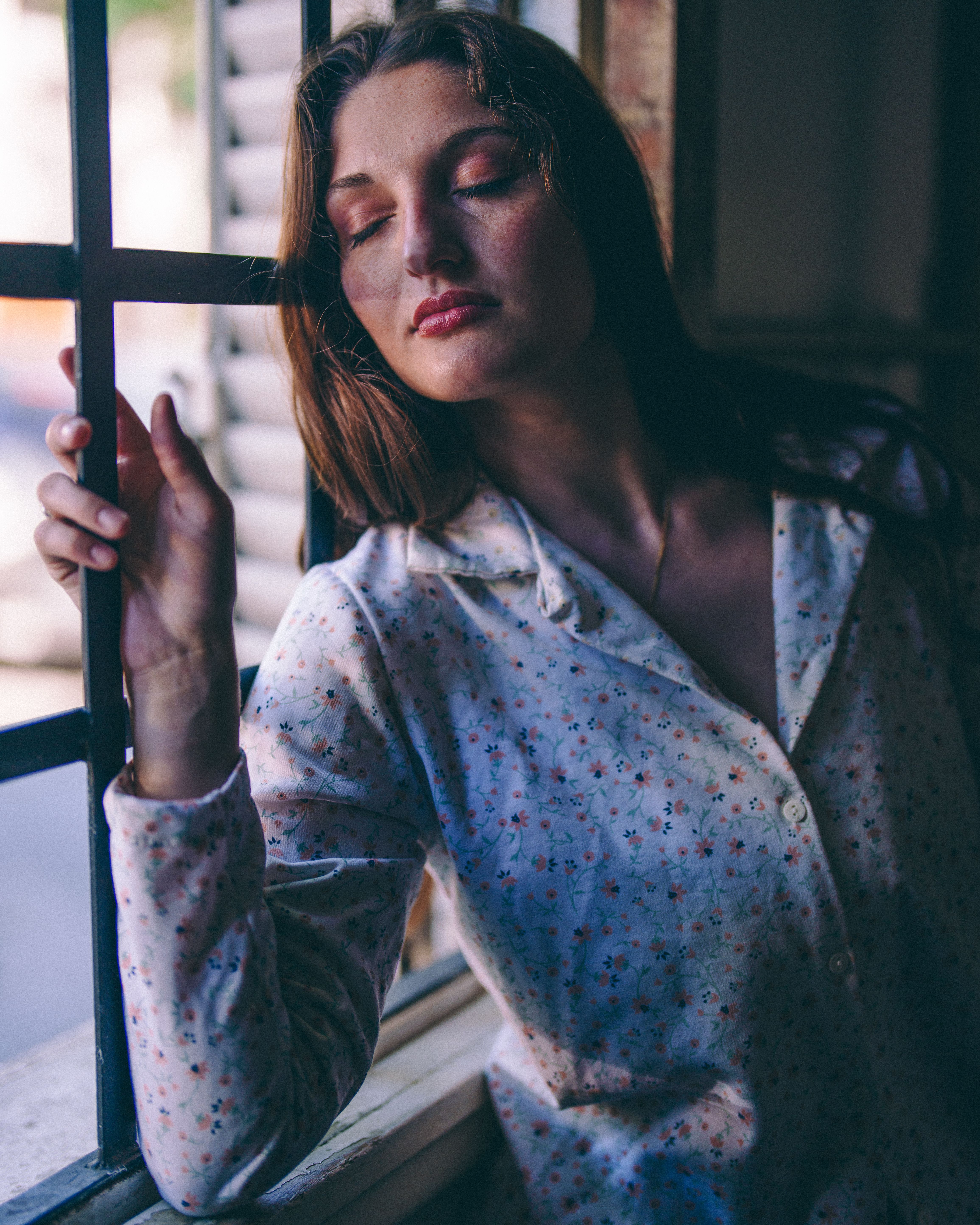 Woman in Floral Pajamas Relaxing by Window Light · Free Stock Photo