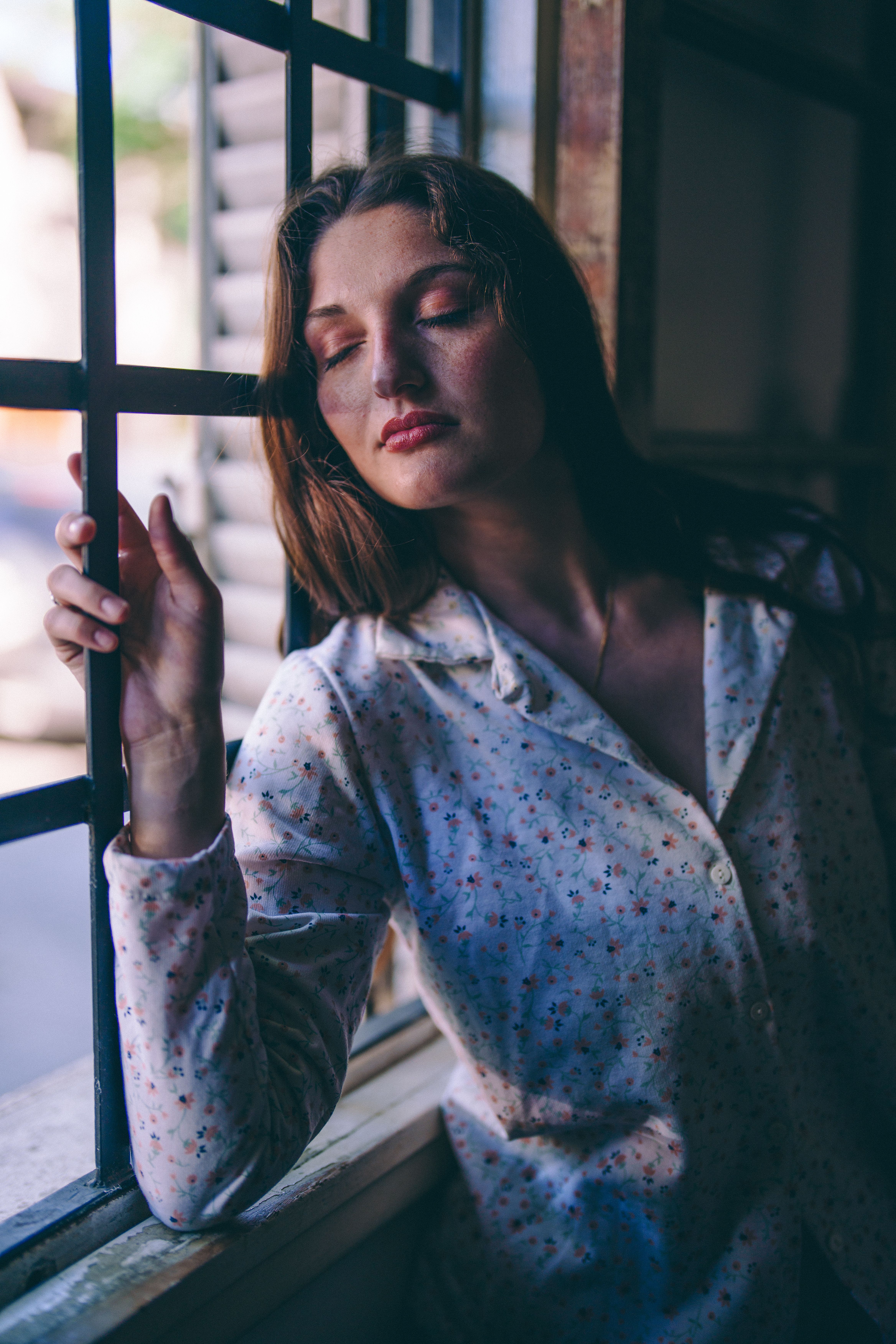 Woman in Pajamas Leaning Against Window with Eyes Closed · Free Stock Photo