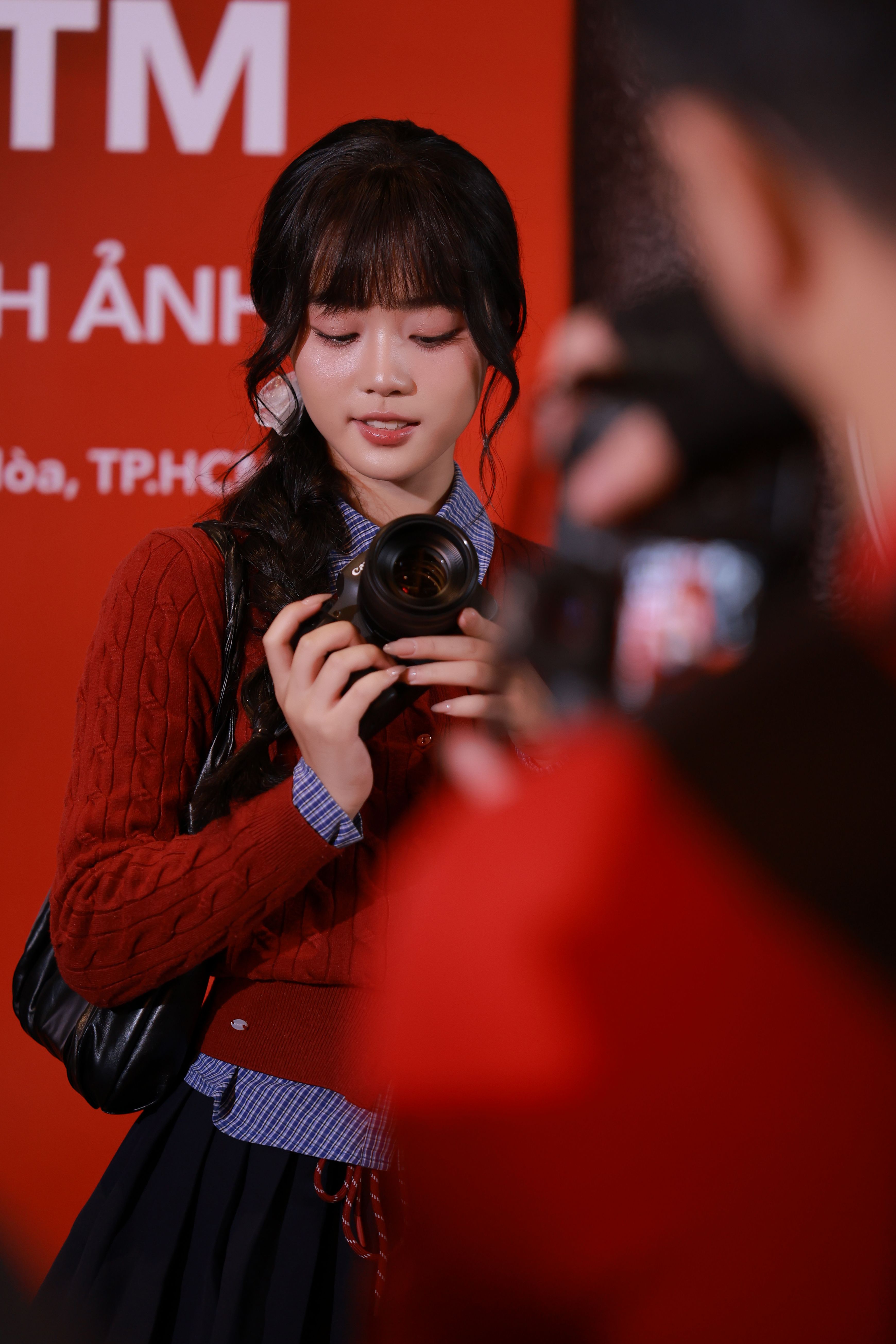 Young Woman Holding Camera at Event · Free Stock Photo