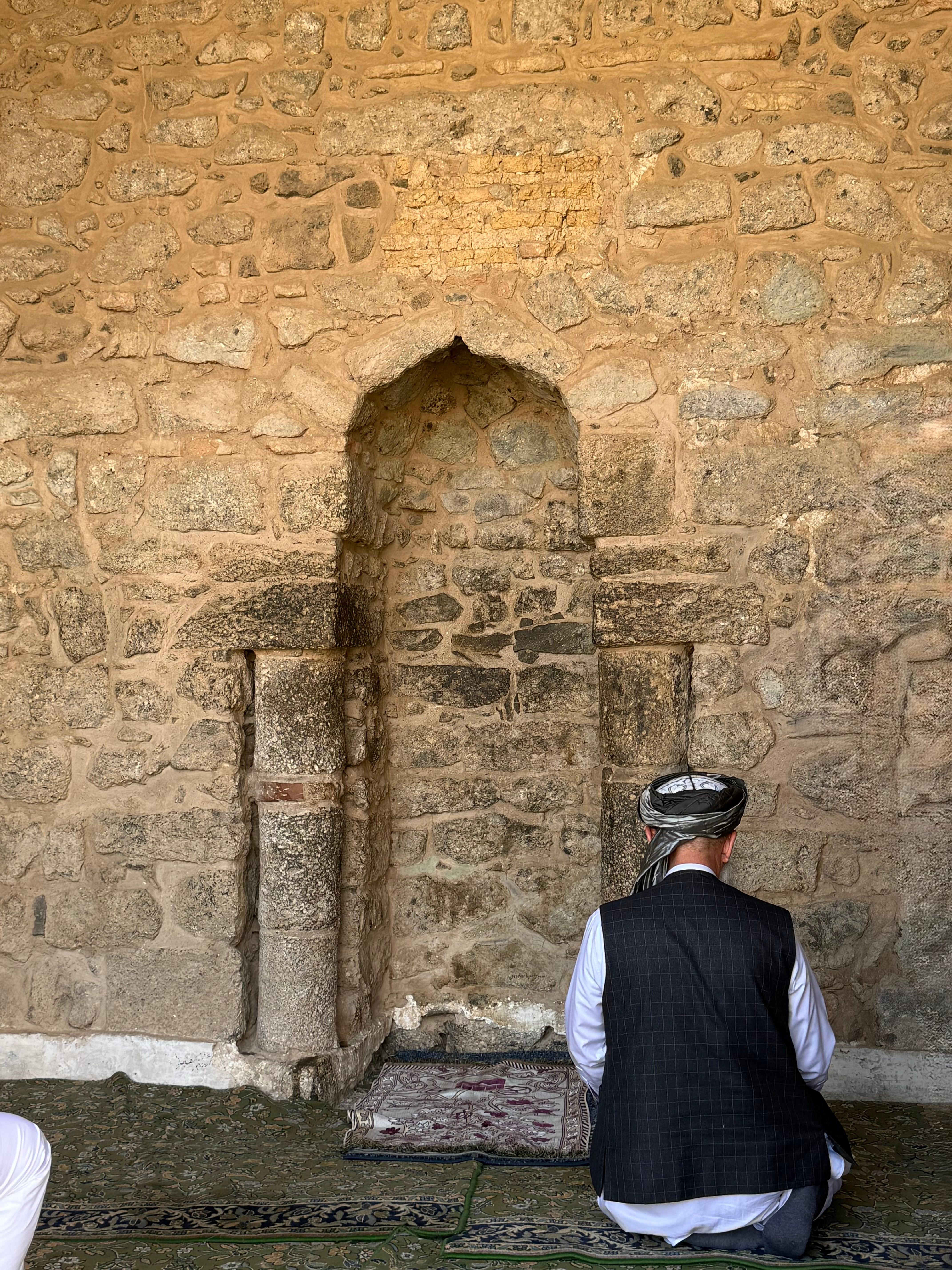 Man Praying in Ancient Stone Structure · Free Stock Photo