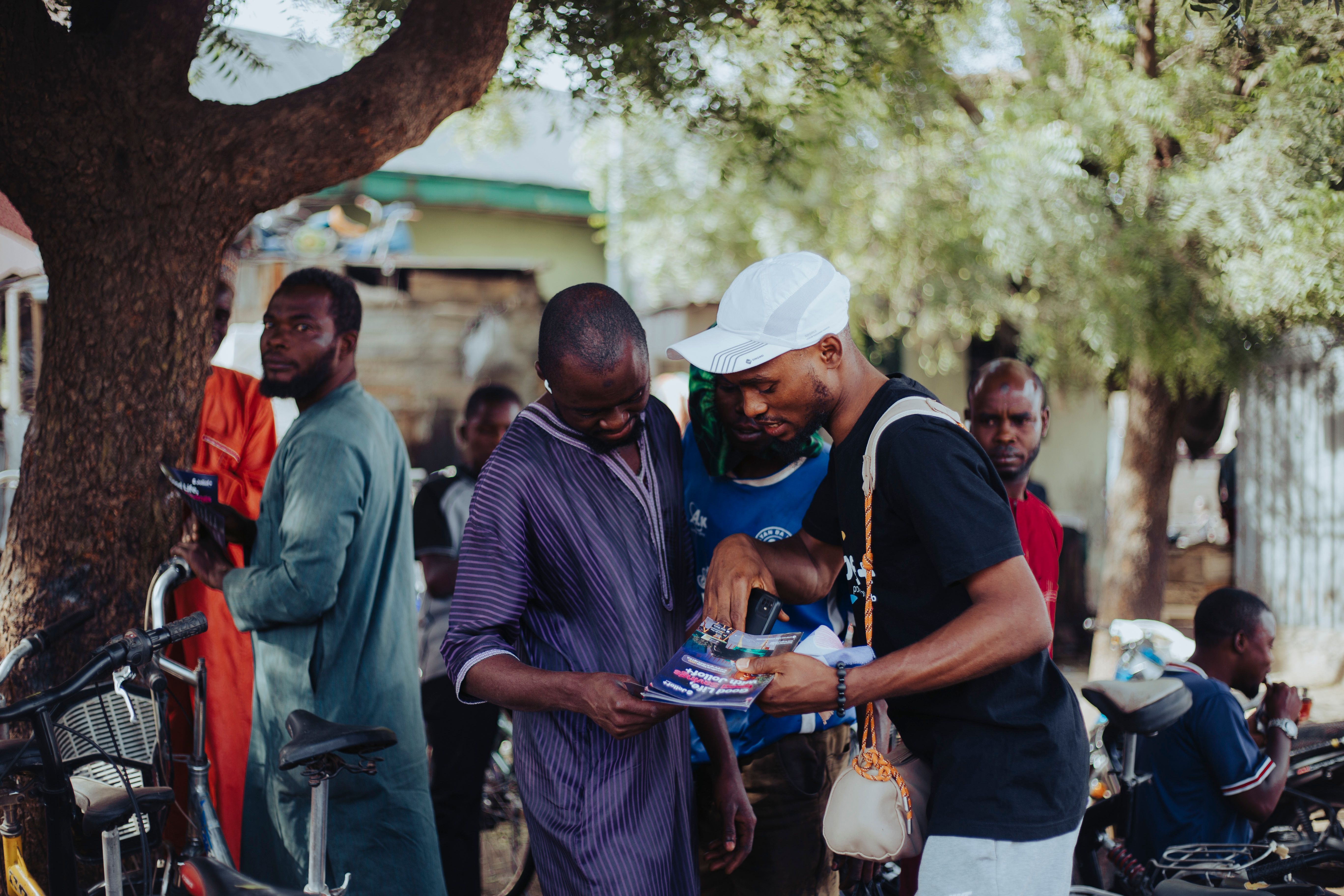 Community Gathering Under Tree in Urban Setting · Free Stock Photo