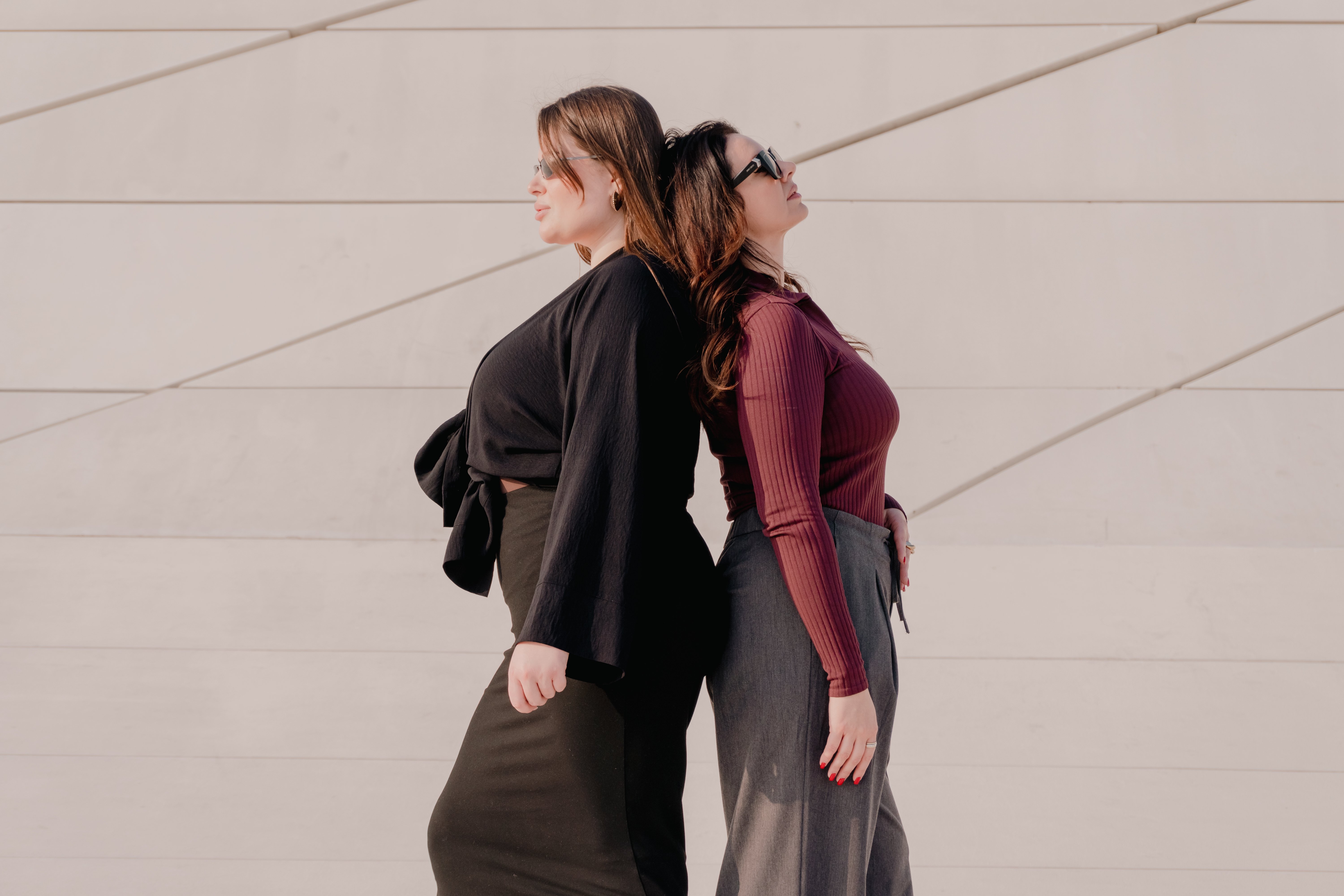 Stylish Women Standing Back to Back Outdoors · Free Stock Photo