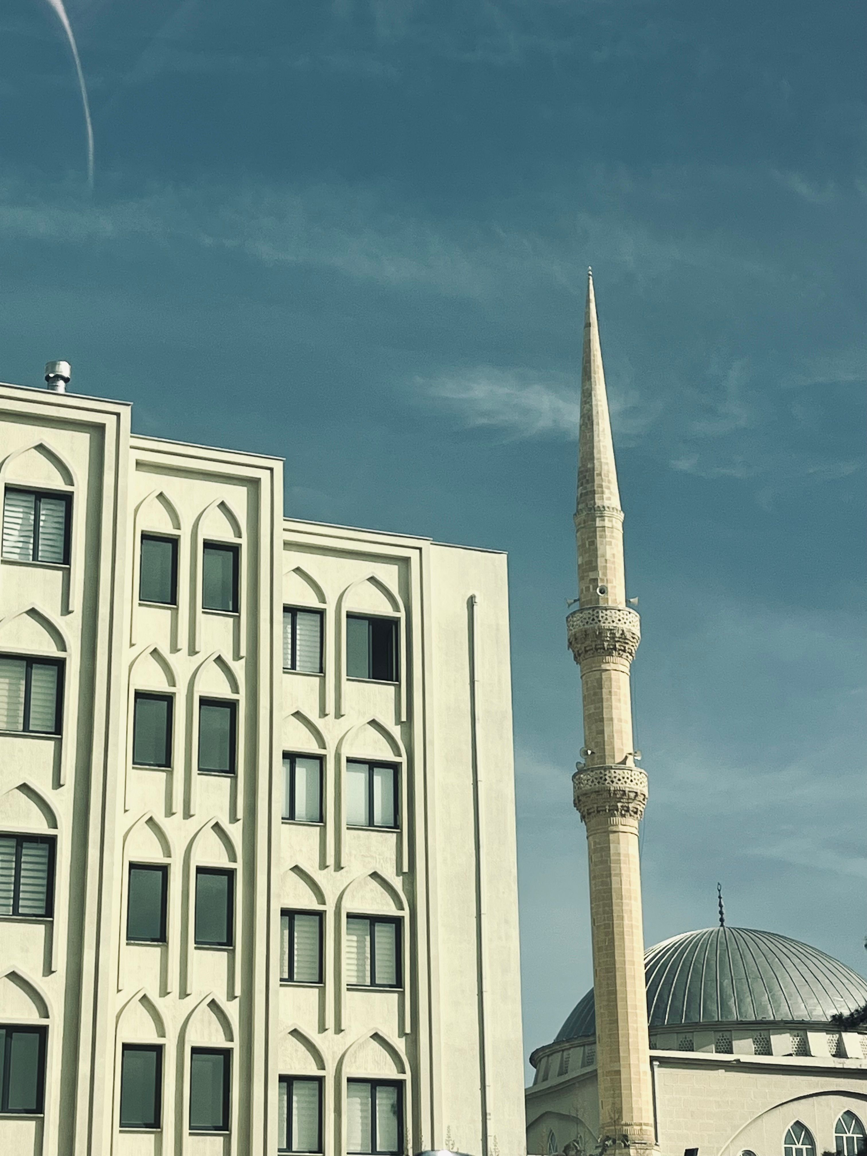 Modern Building Next to Traditional Mosque Minaret · Free Stock Photo