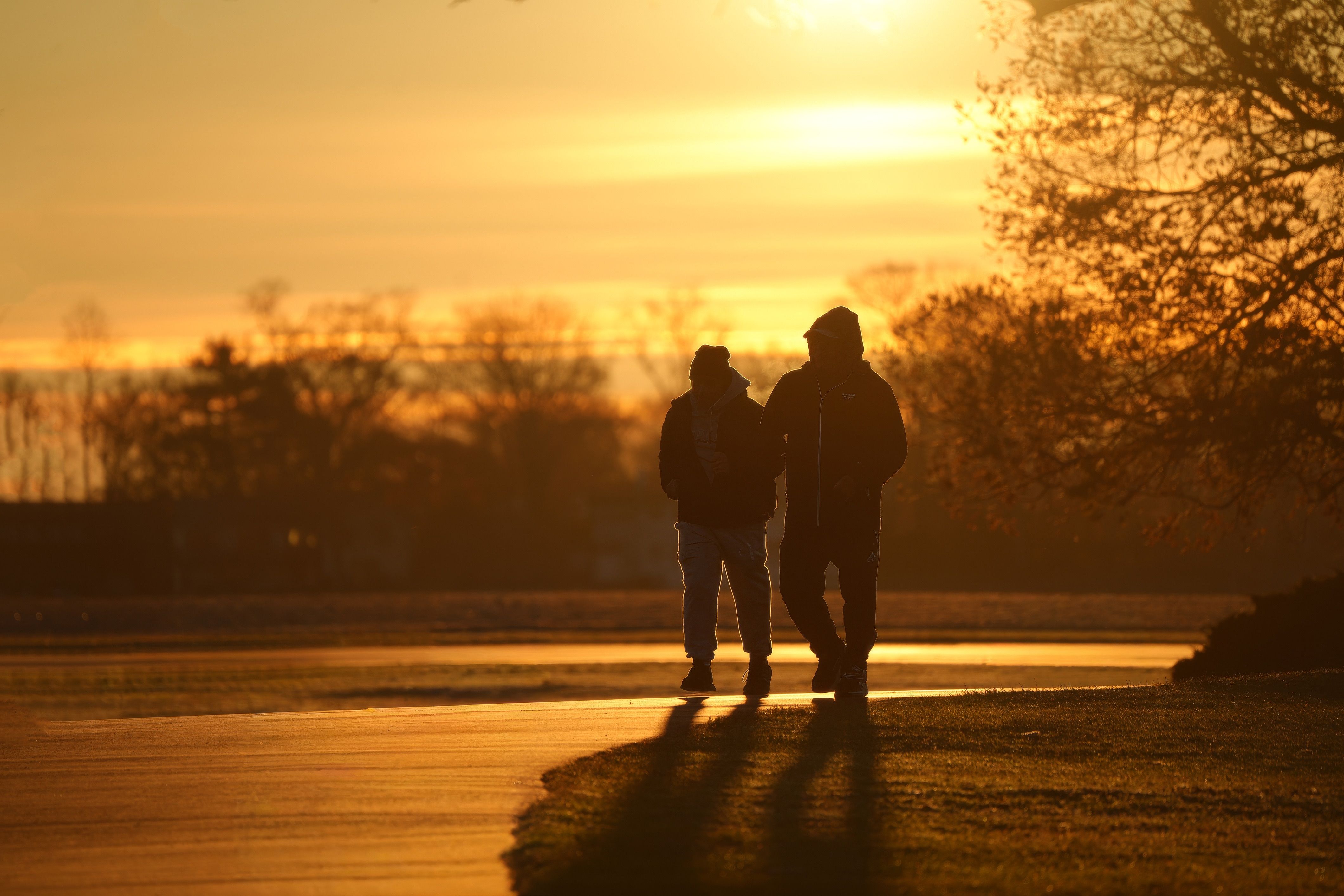 Two People Walking at Sunrise in Park · Free Stock Photo