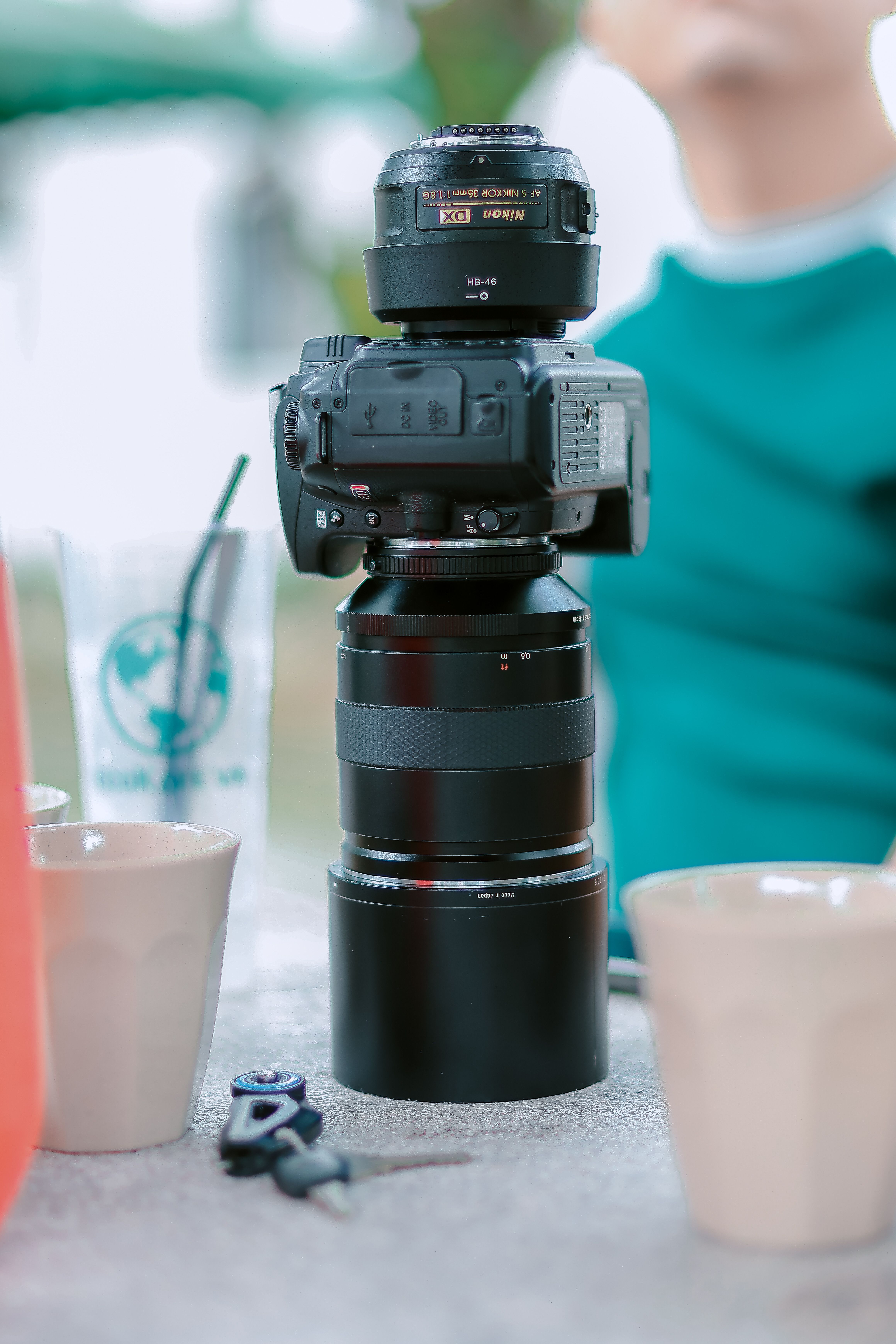 Stacked Camera Lenses with DSLR on Café Table · Free Stock Photo