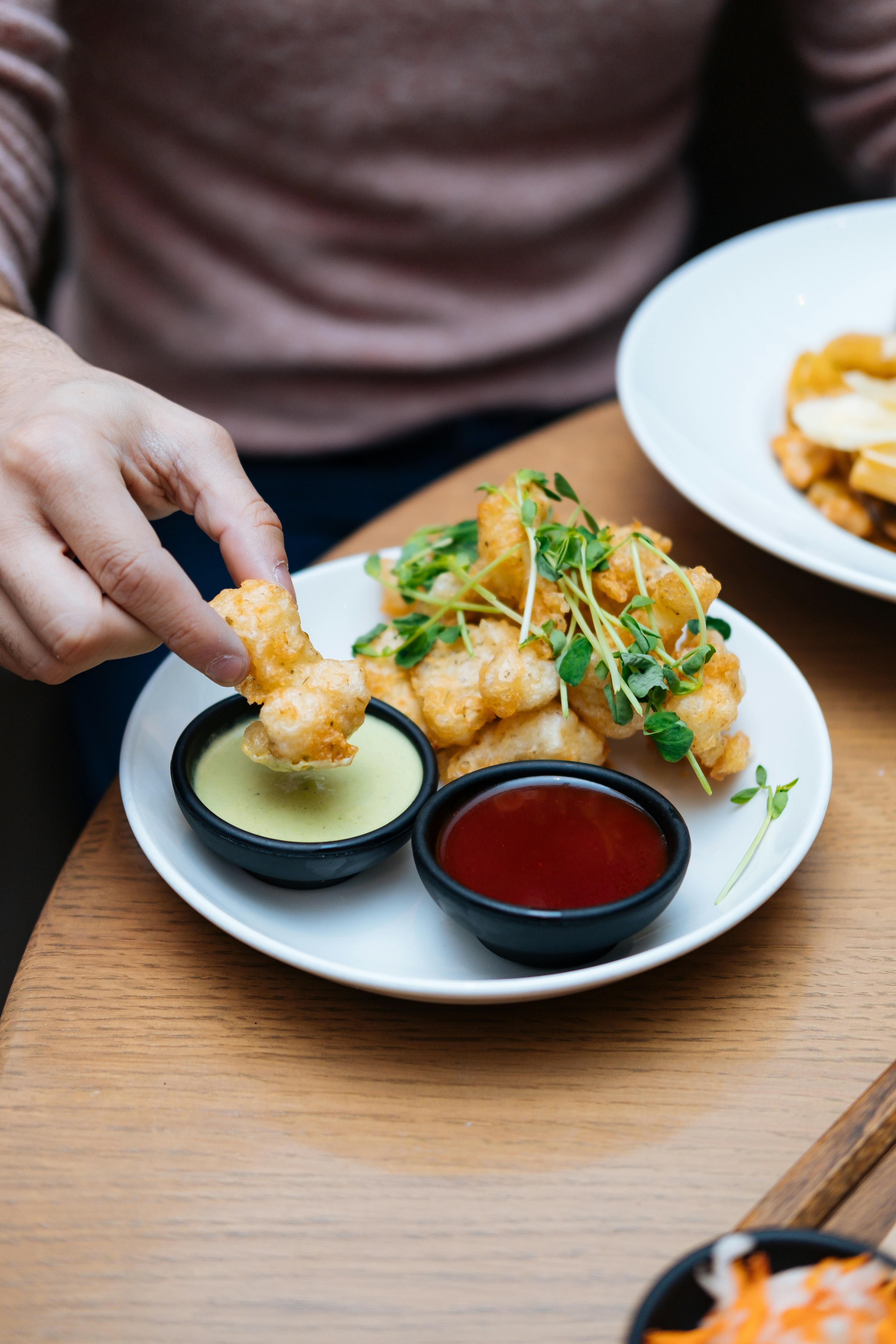 Person Dipping Fried Food on Sauce · Free Stock Photo
