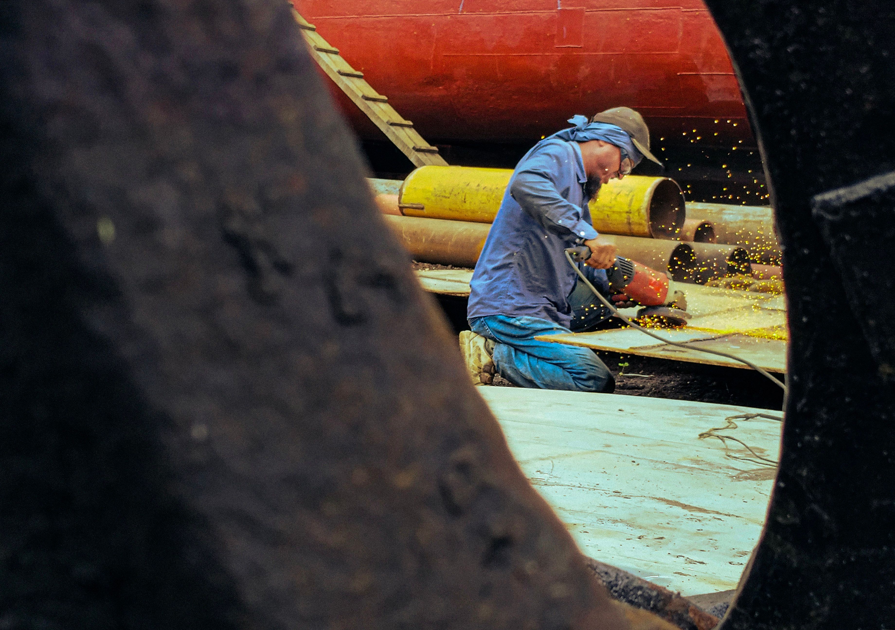 Shipyard Worker Cutting Metal with Power Tool · Free Stock Photo