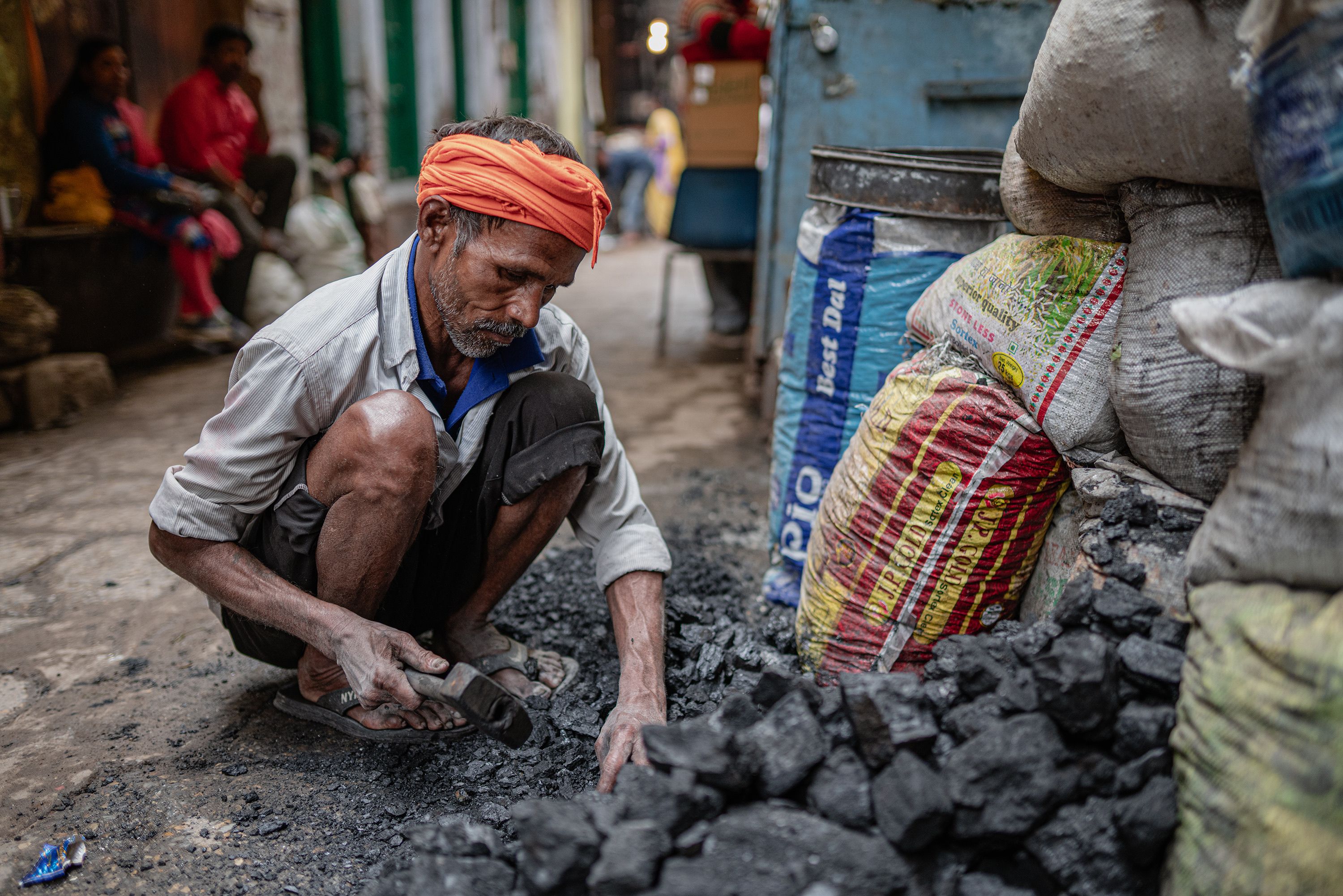 Man Sorting Coal in a Busy Market Street · Free Stock Photo