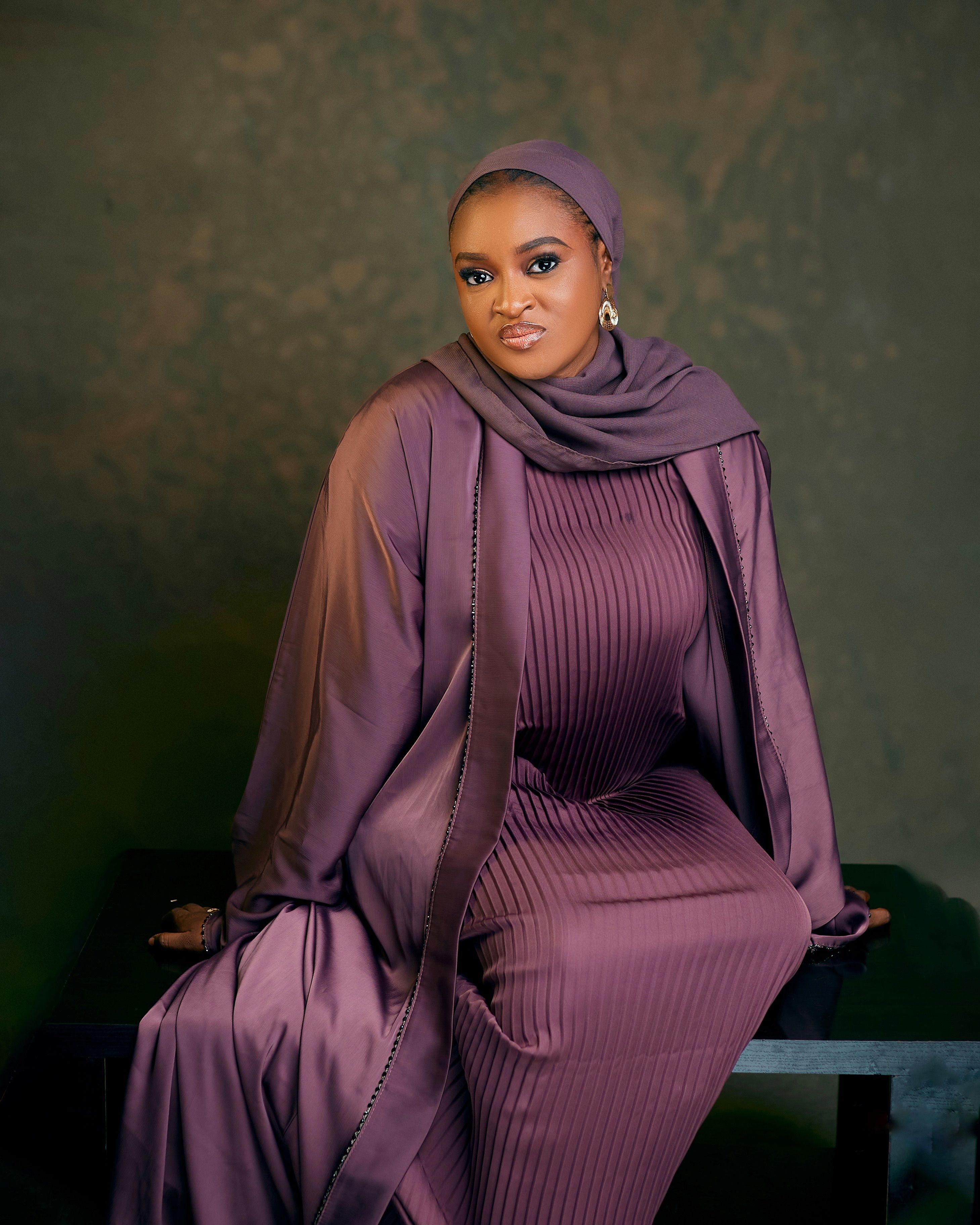 Elegant Woman in Purple Abaya Sitting Indoors · Free Stock Photo