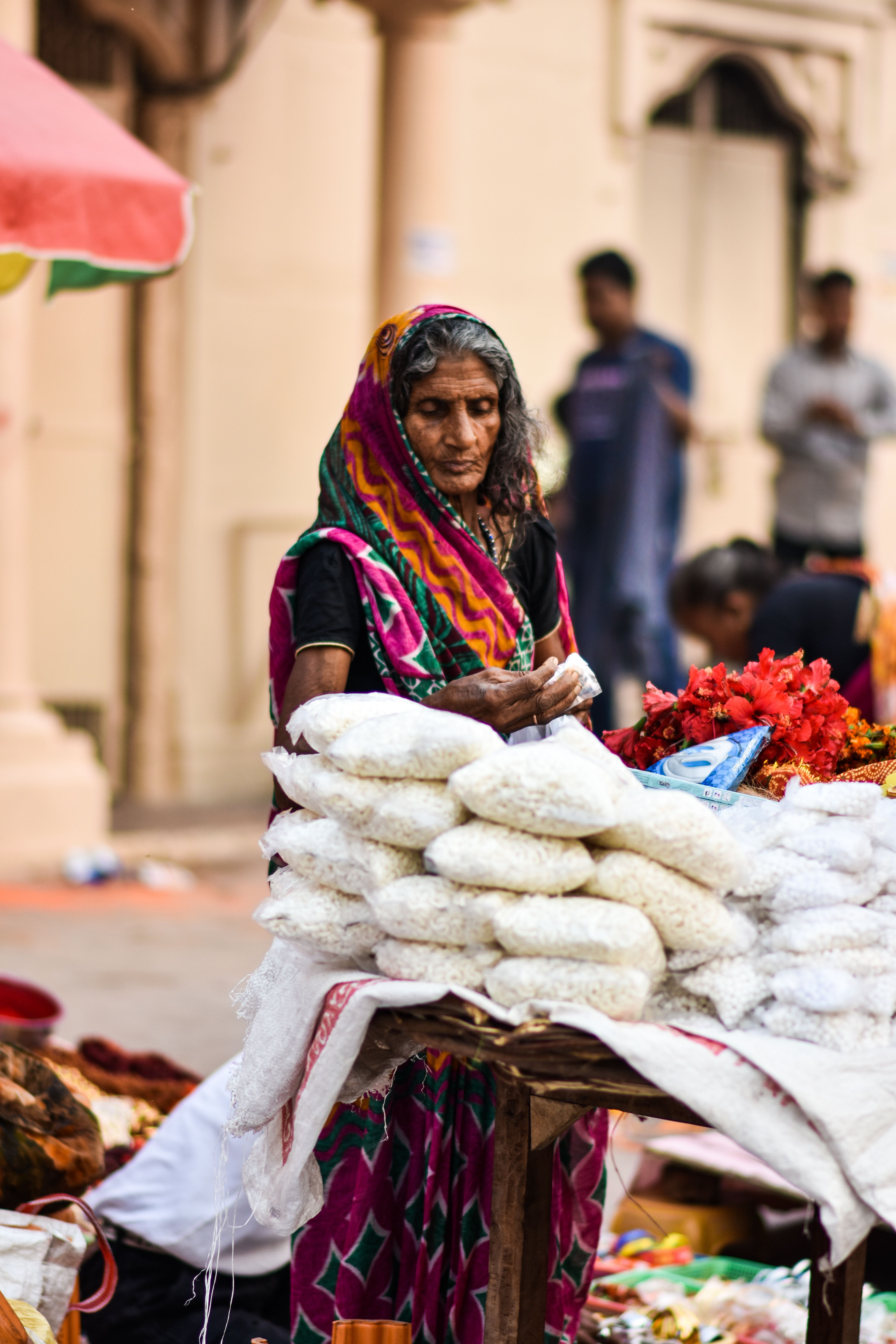 Elderly Woman Selling Goods at Outdoor Market · Free Stock Photo