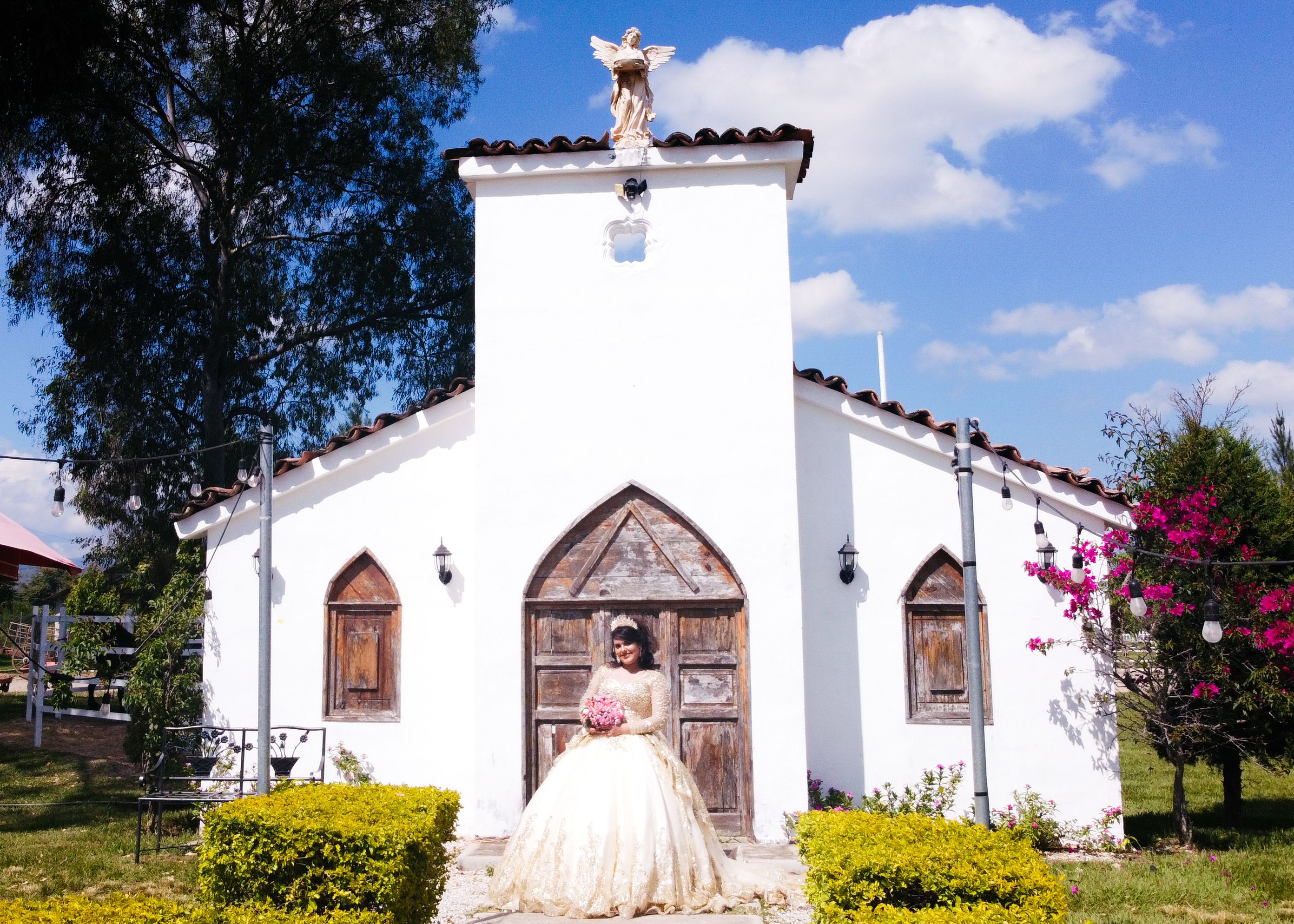 Bride Posing in Front of Picturesque Chapel · Free Stock Photo