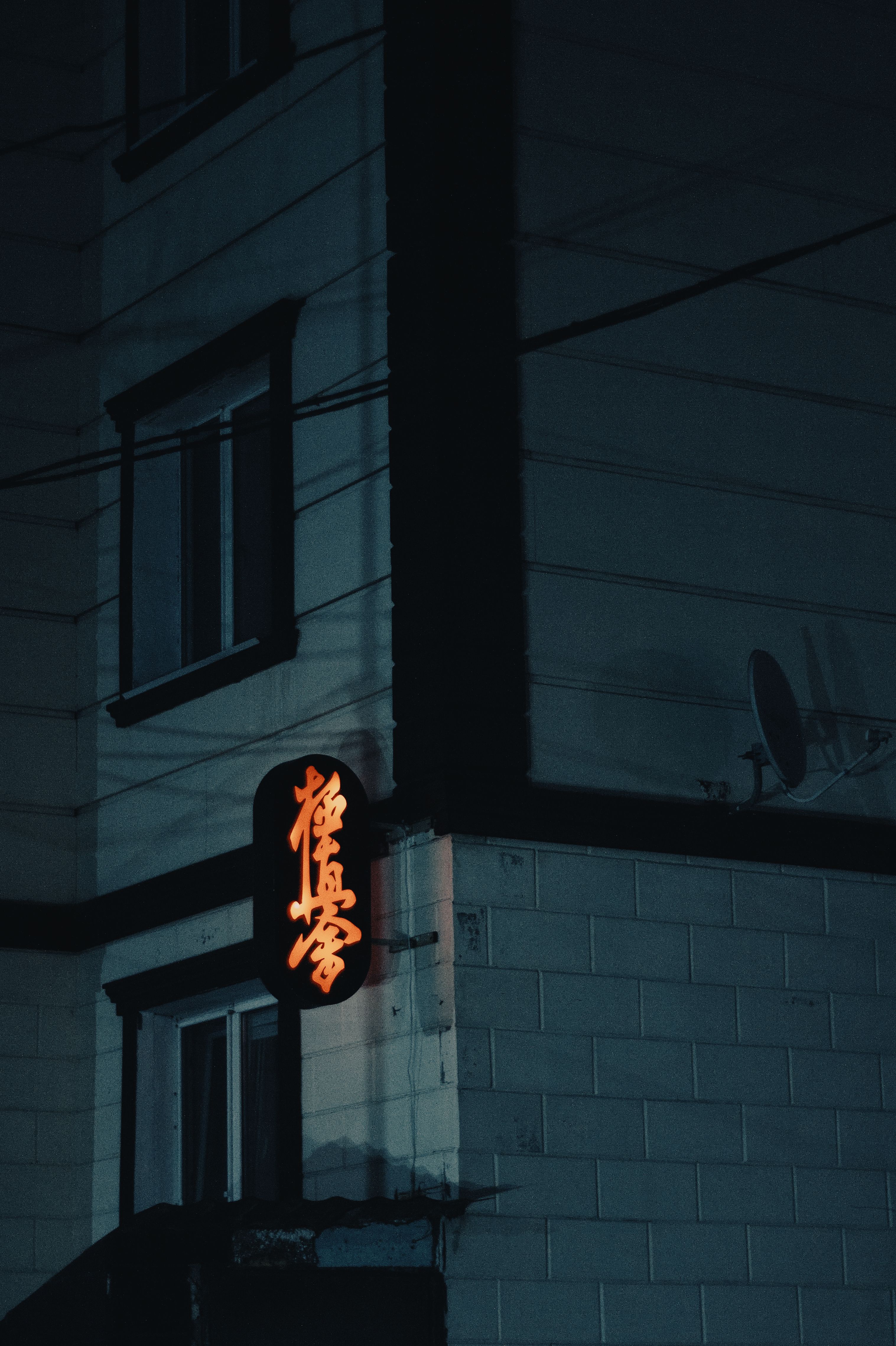 Moody Nighttime Urban Building with Neon Sign · Free Stock Photo