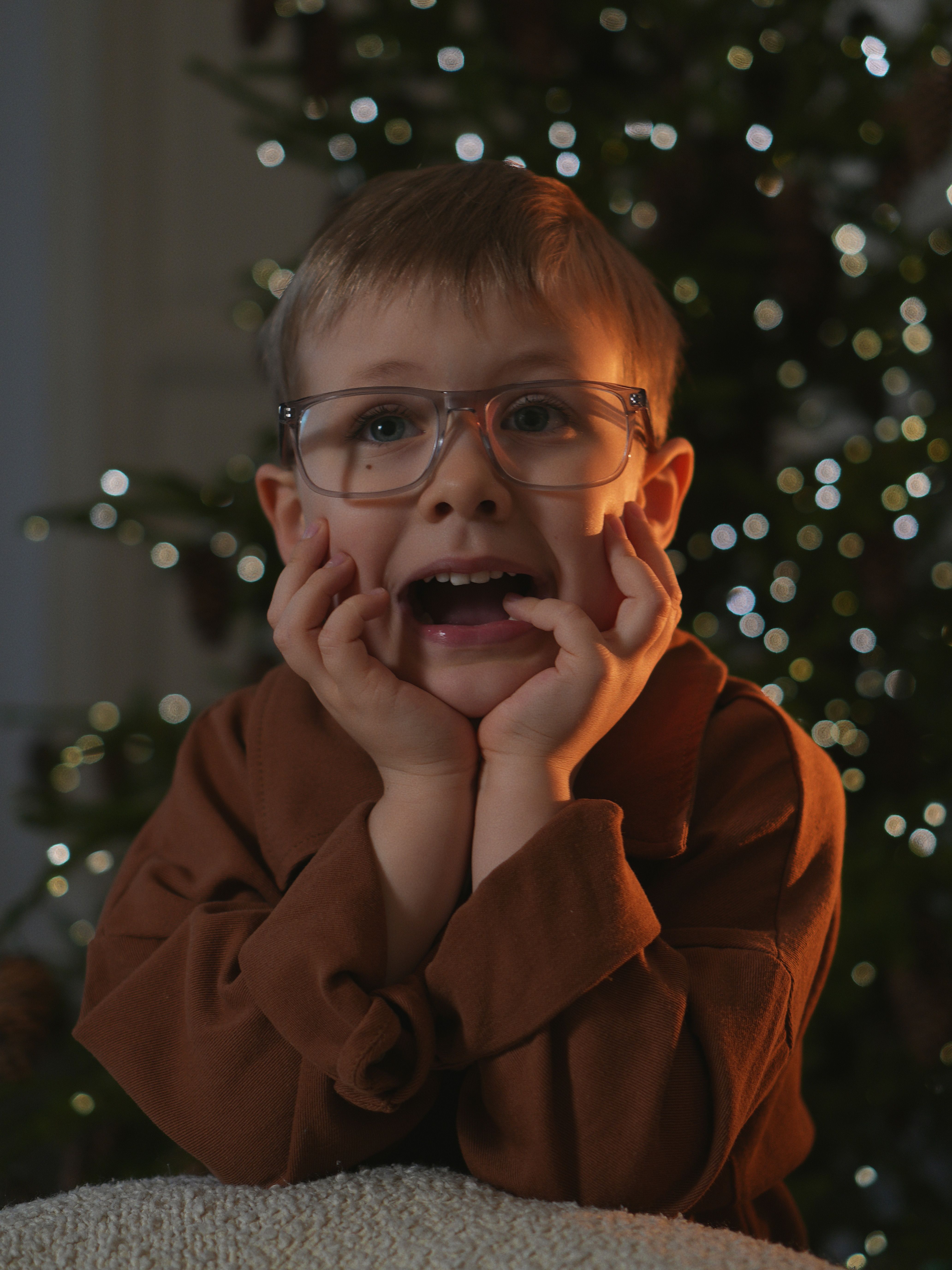 Excited Child by Christmas Tree Background · Free Stock Photo