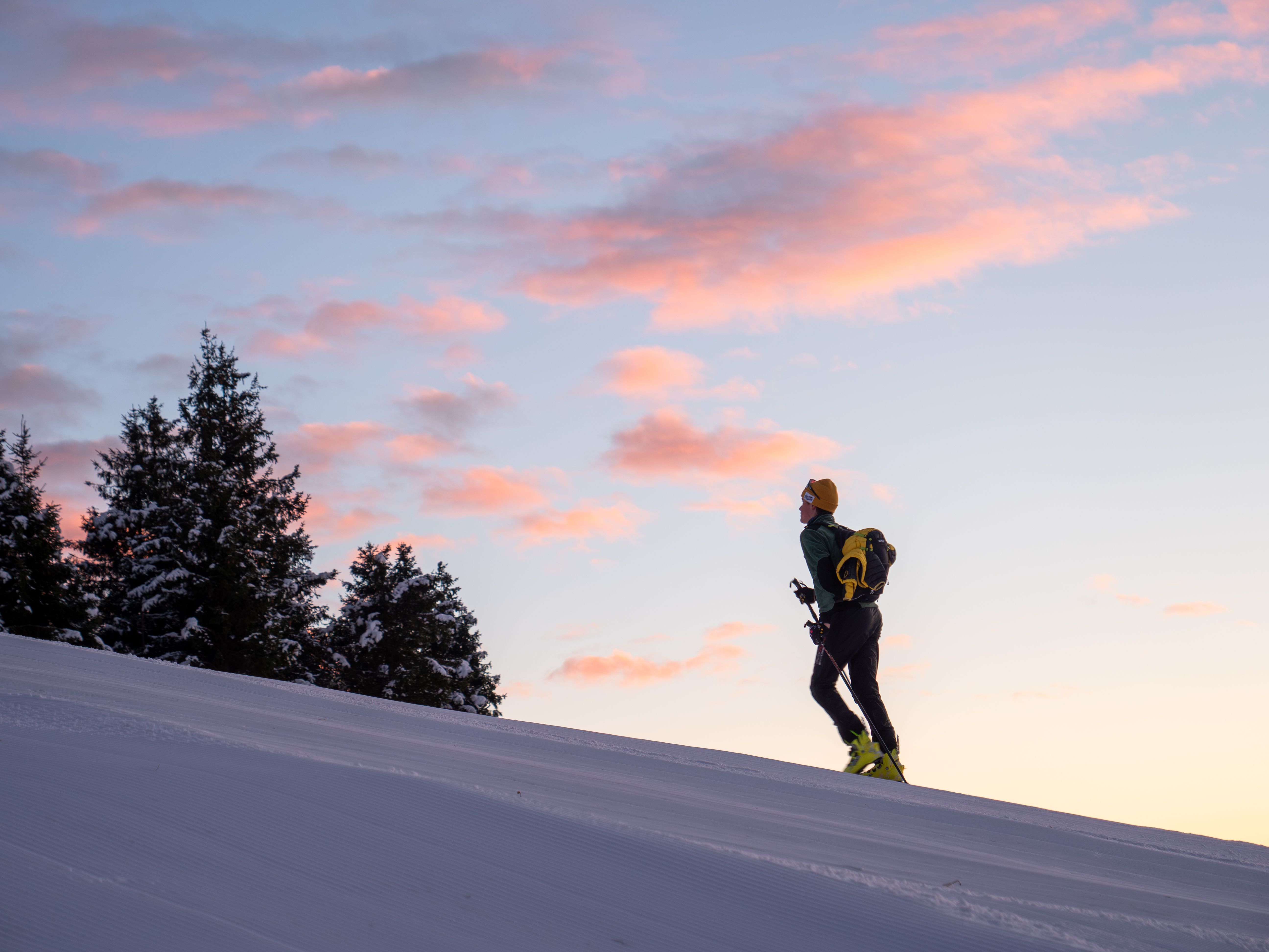 Skier Ascends Snowy Mountain at Sunset · Free Stock Photo