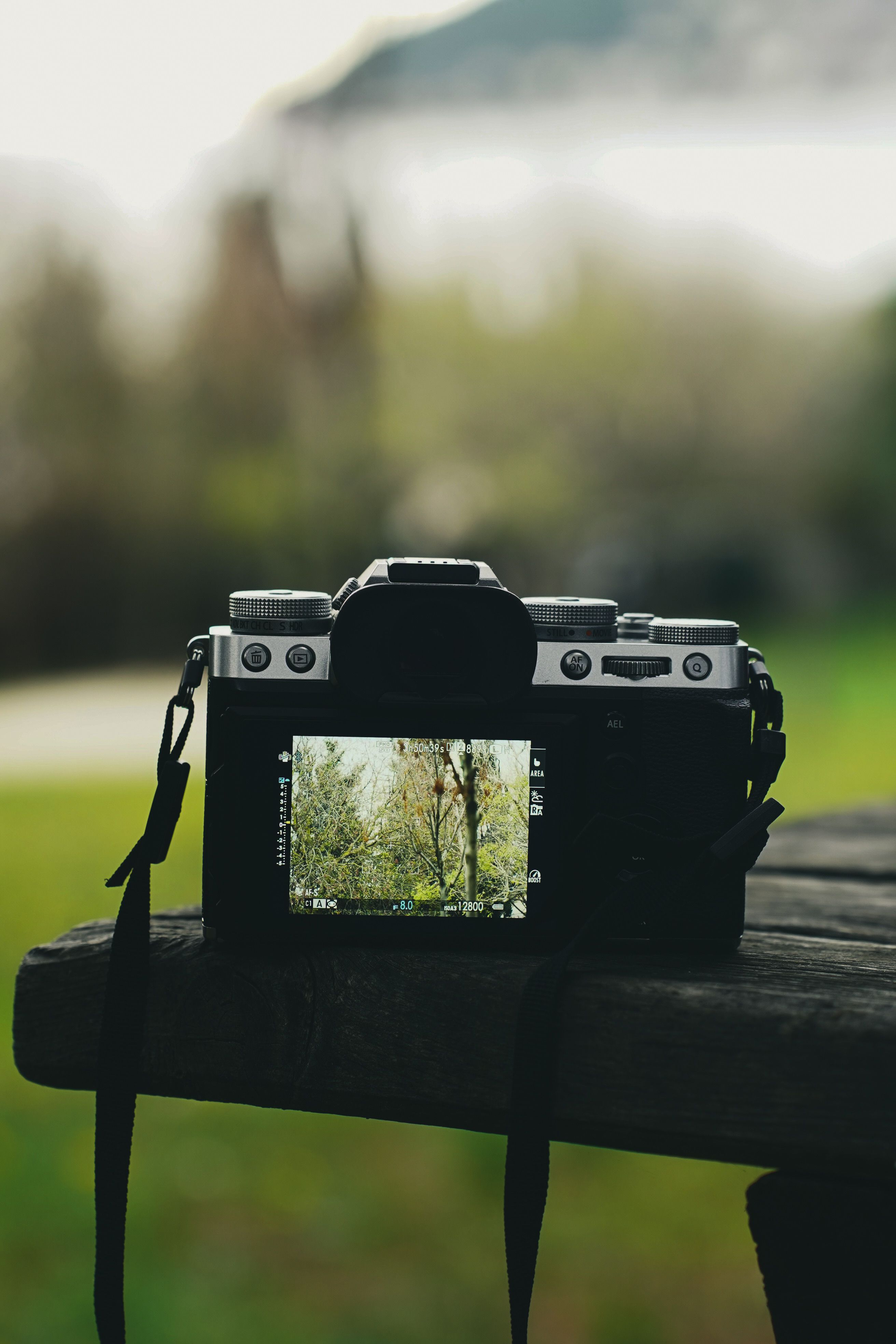 Camera on Wooden Table Capturing Nature Outdoors · Free Stock Photo