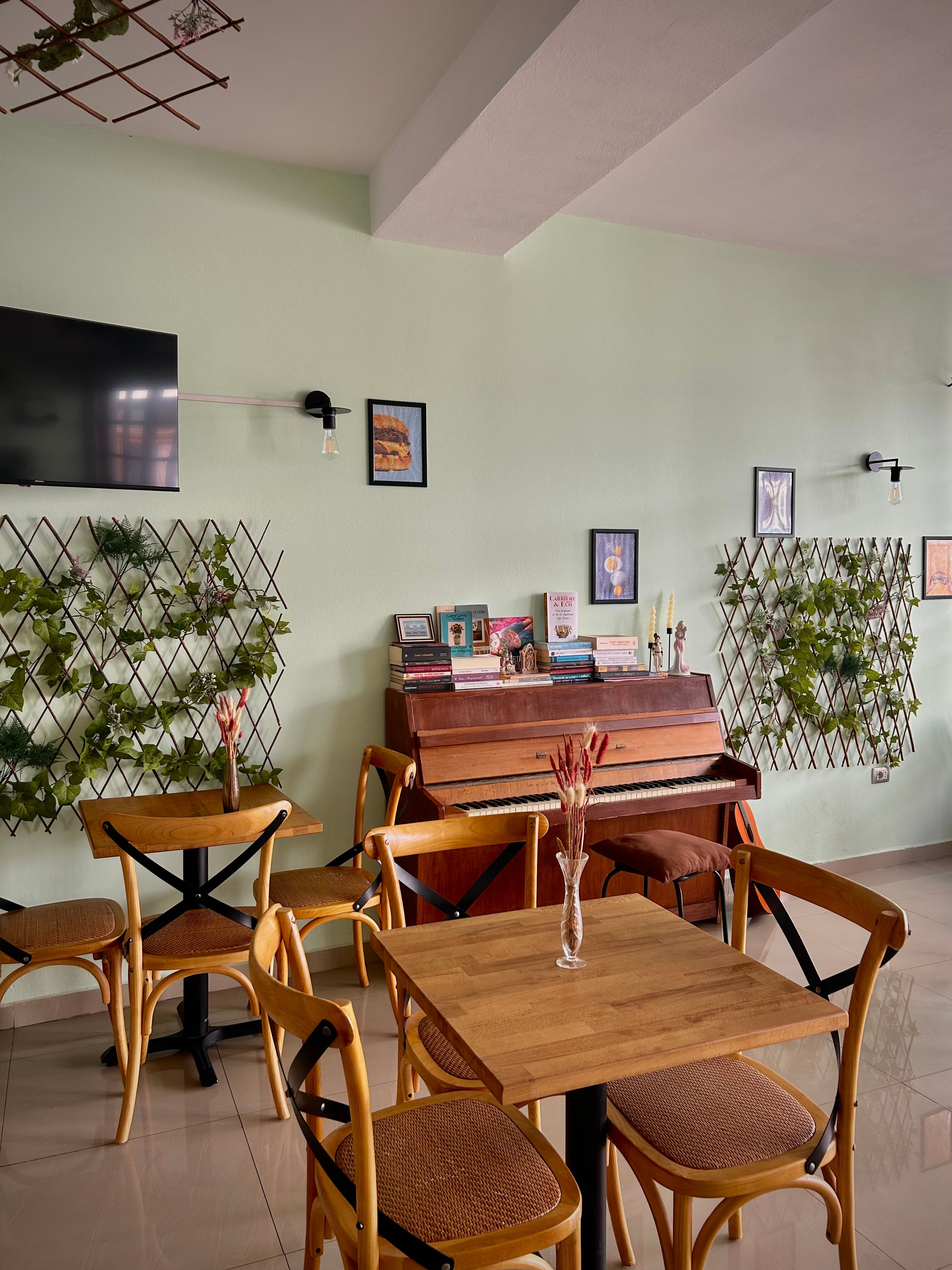 Cozy Cafe Interior with Piano and Greenery · Free Stock Photo
