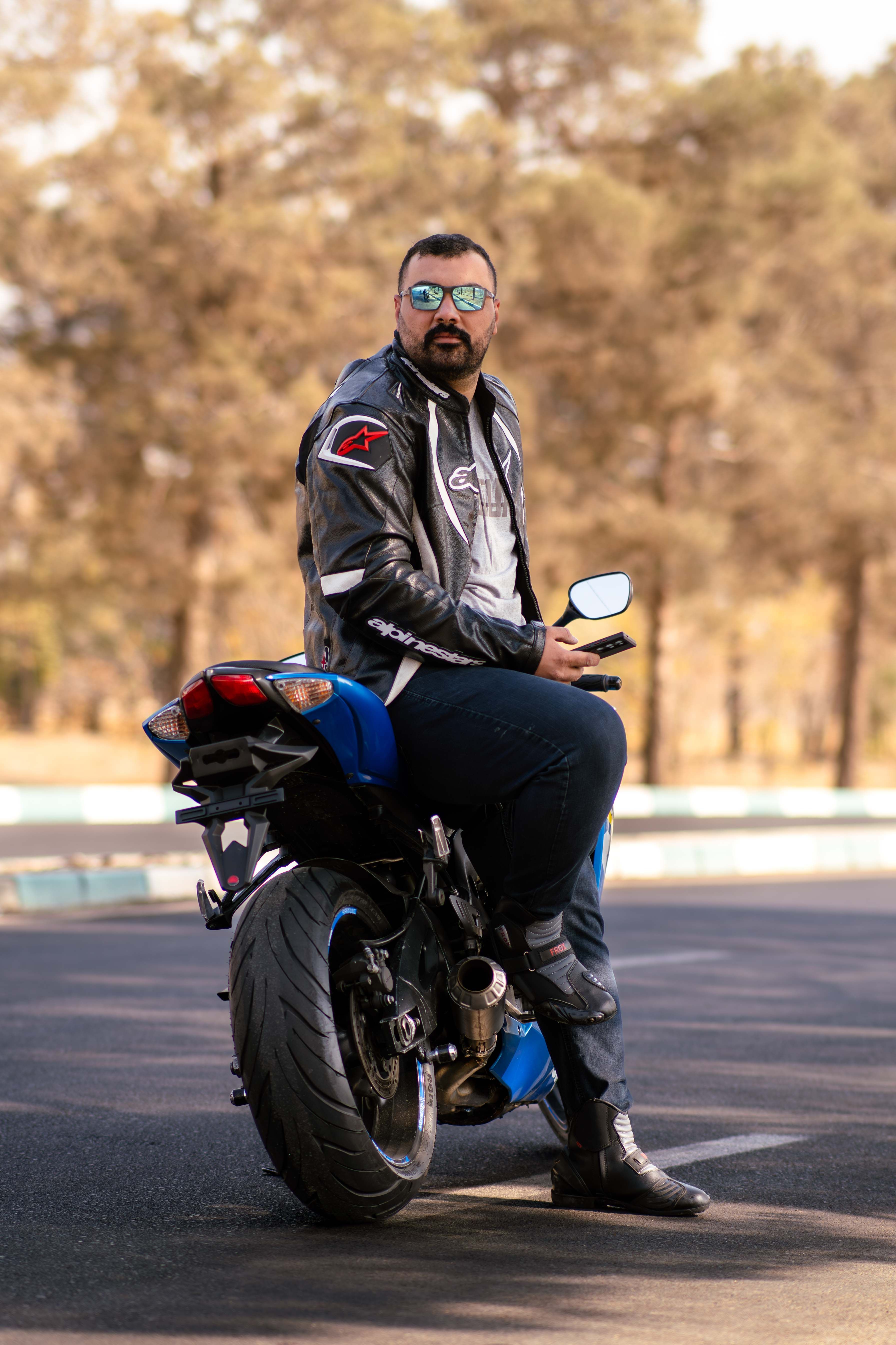 Stylish Biker Posing with Motorcycle Outdoors · Free Stock Photo