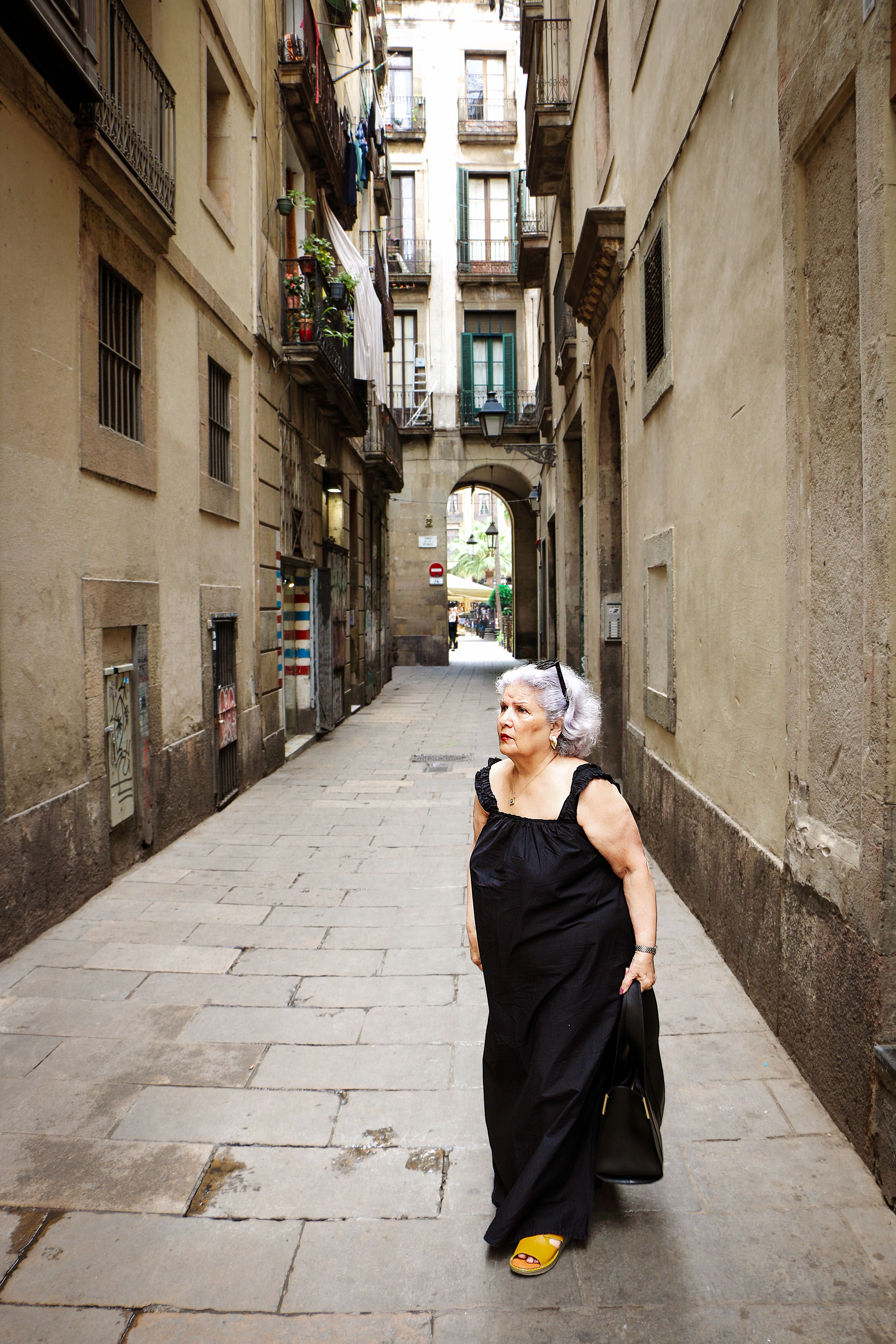 Elderly Woman Strolling in Historic Barcelona Street · Free Stock Photo