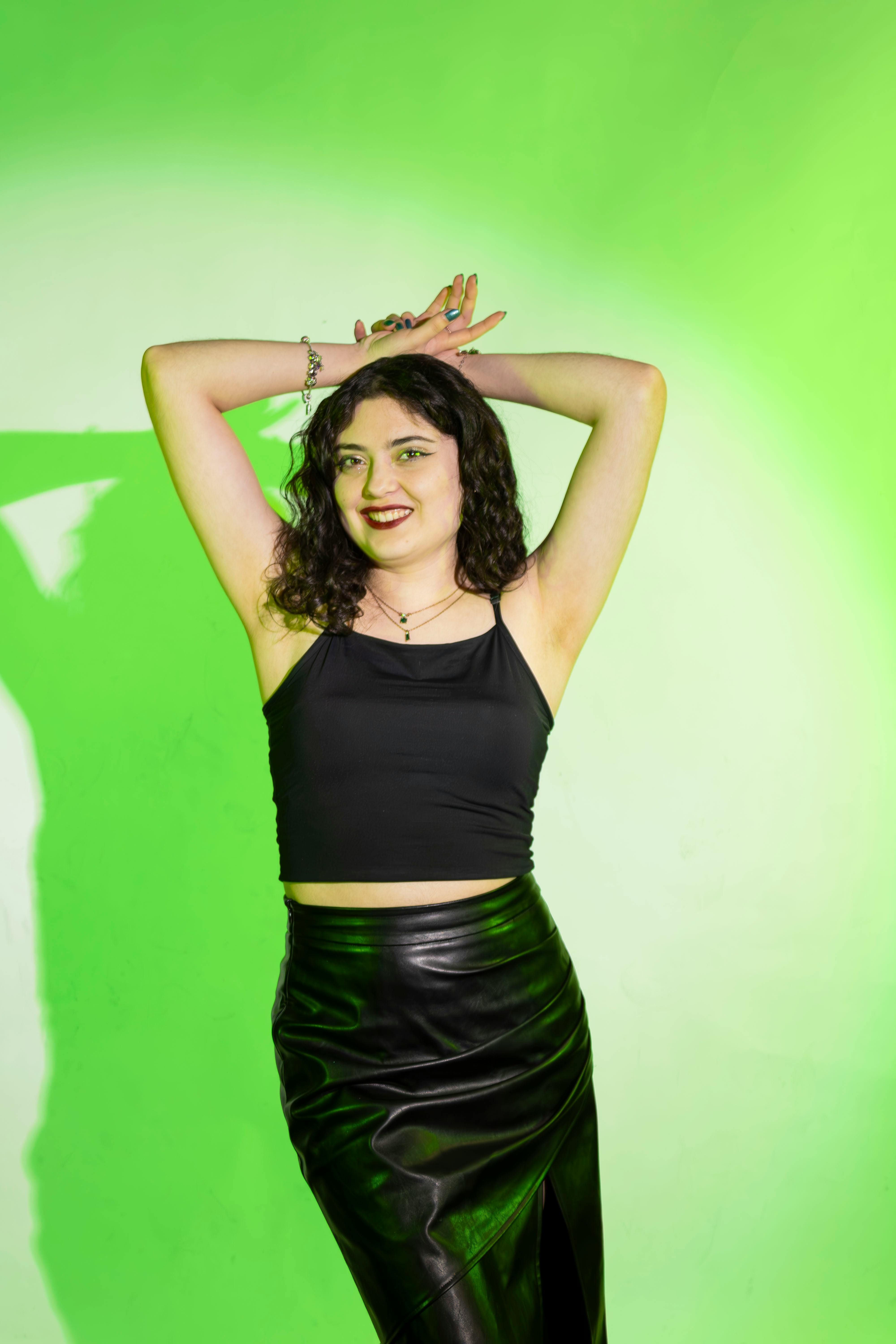 Young Woman in Black Attire Against Green Light · Free Stock Photo