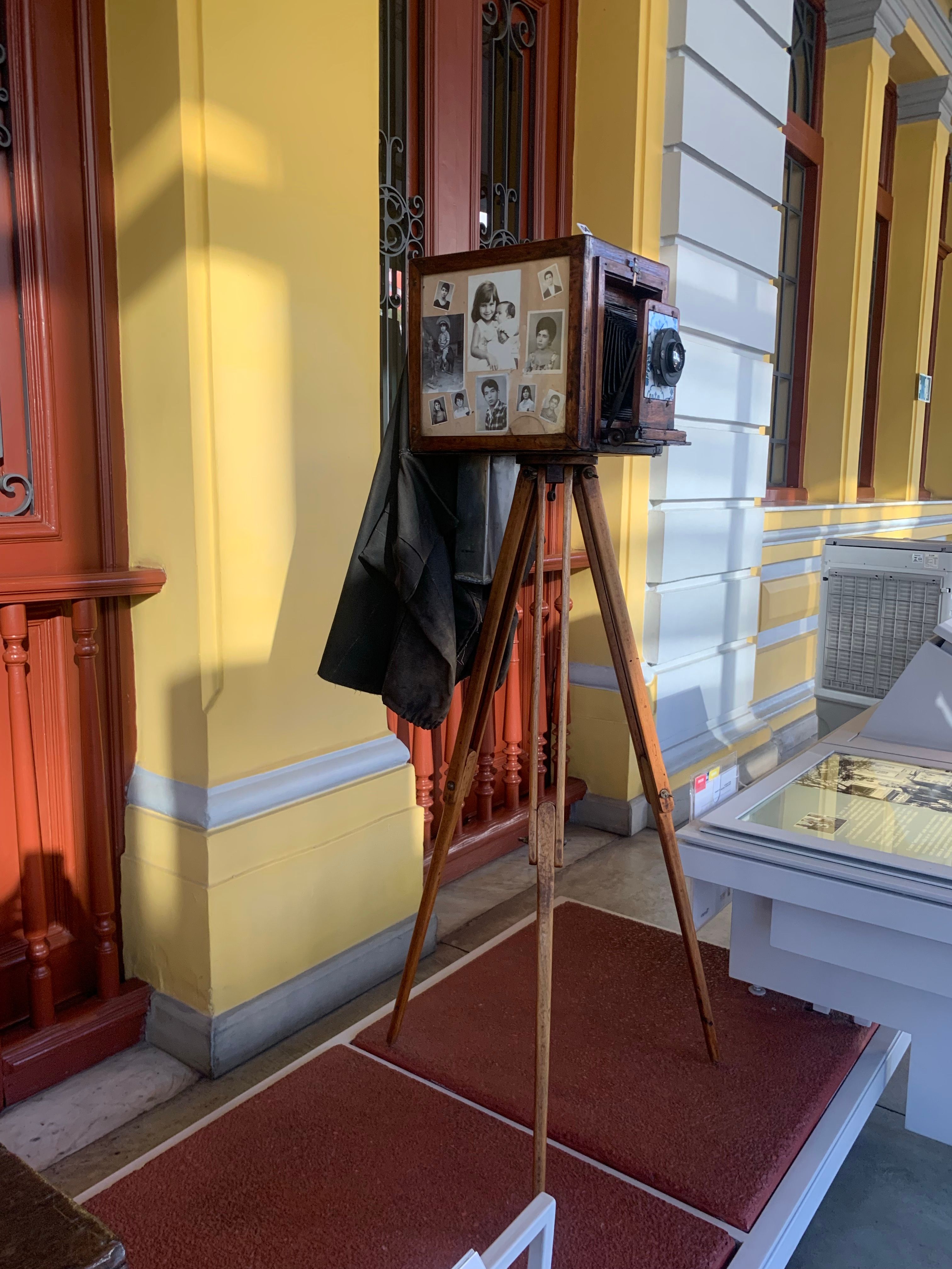 Vintage Wooden Camera Display in Sunlit Corridor · Free Stock Photo